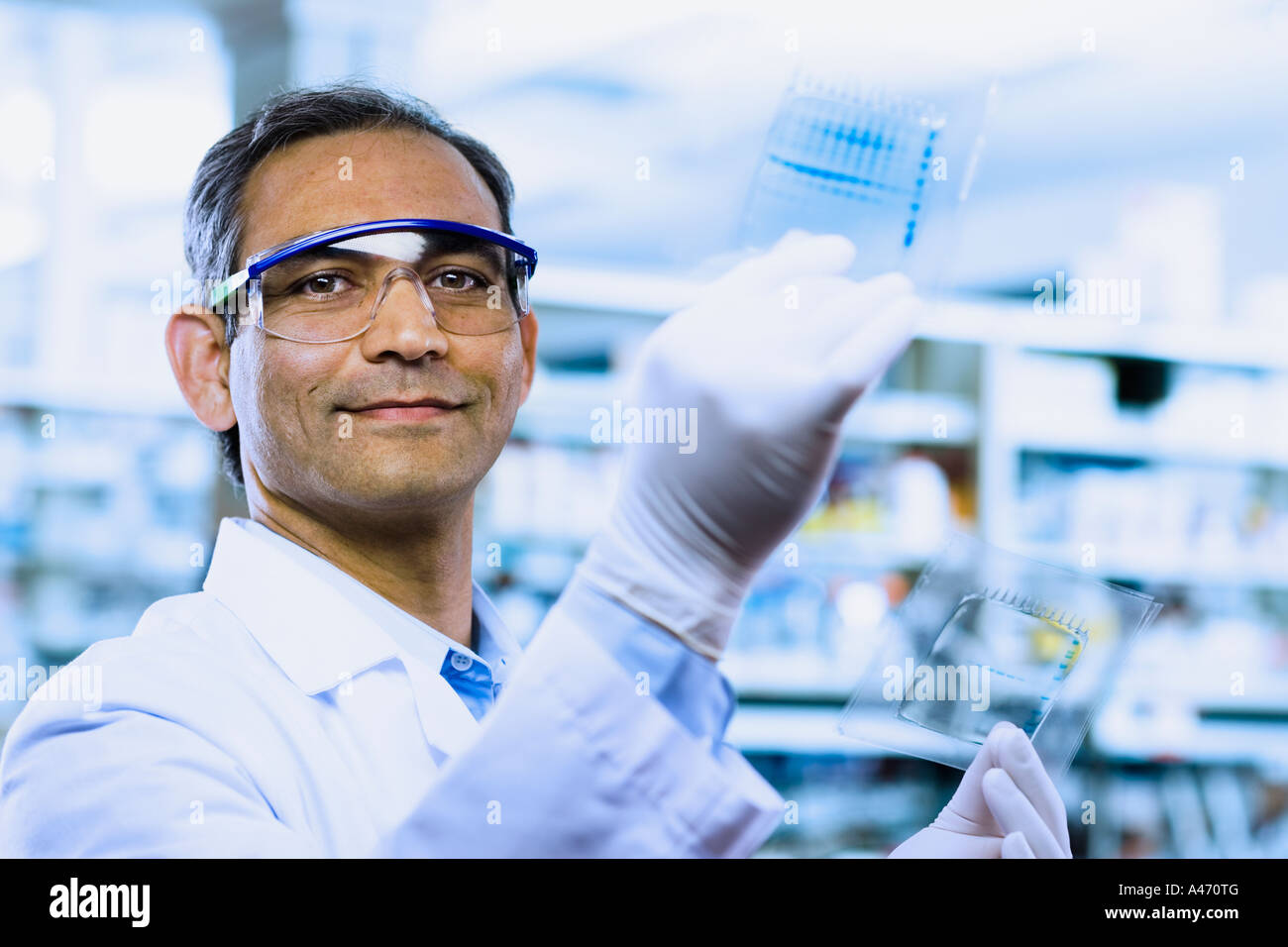 Indian male scientist smiling and holding DNA film Stock Photo - Alamy