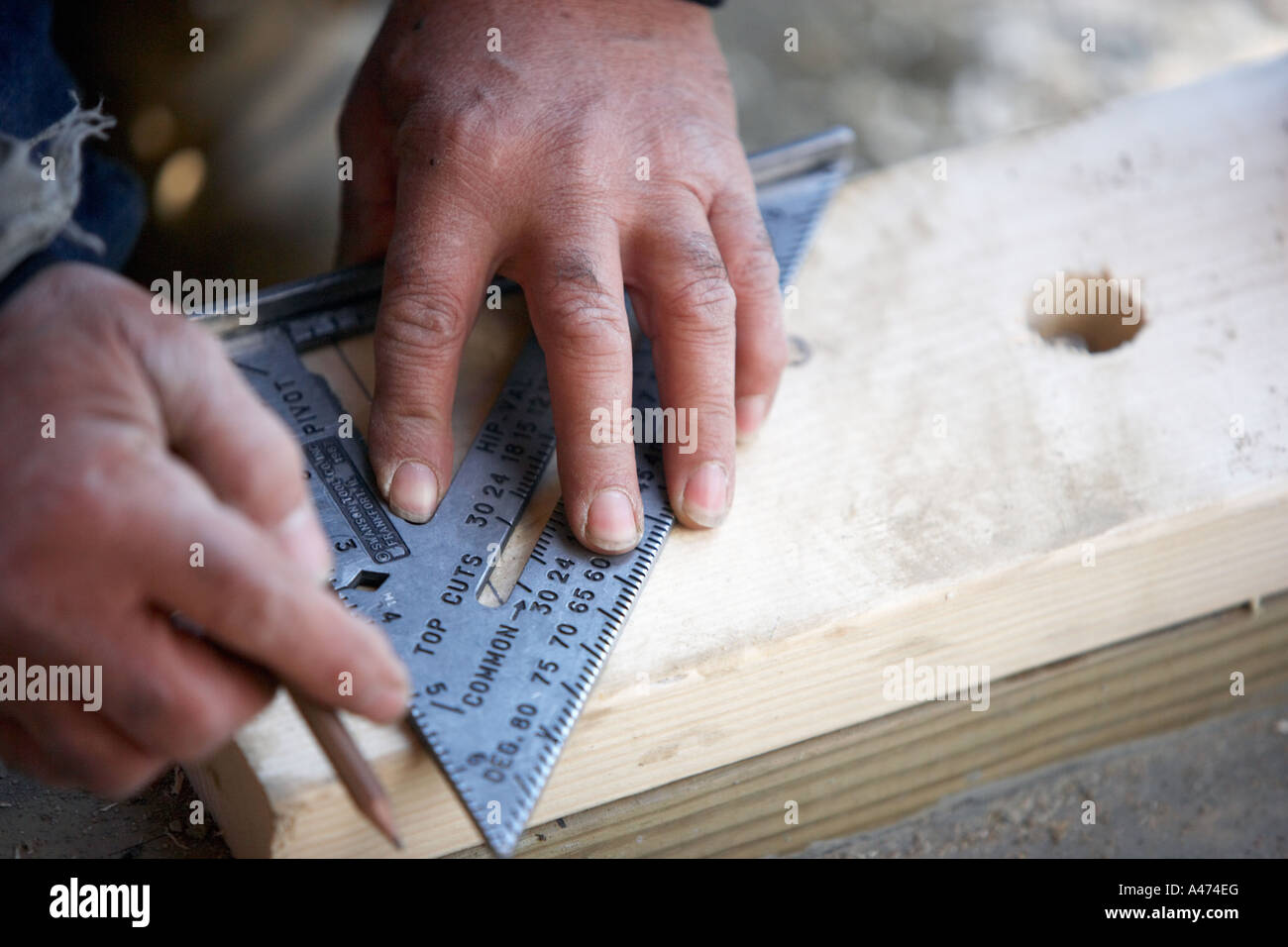 Construction worker squaring up board Stock Photo - Alamy