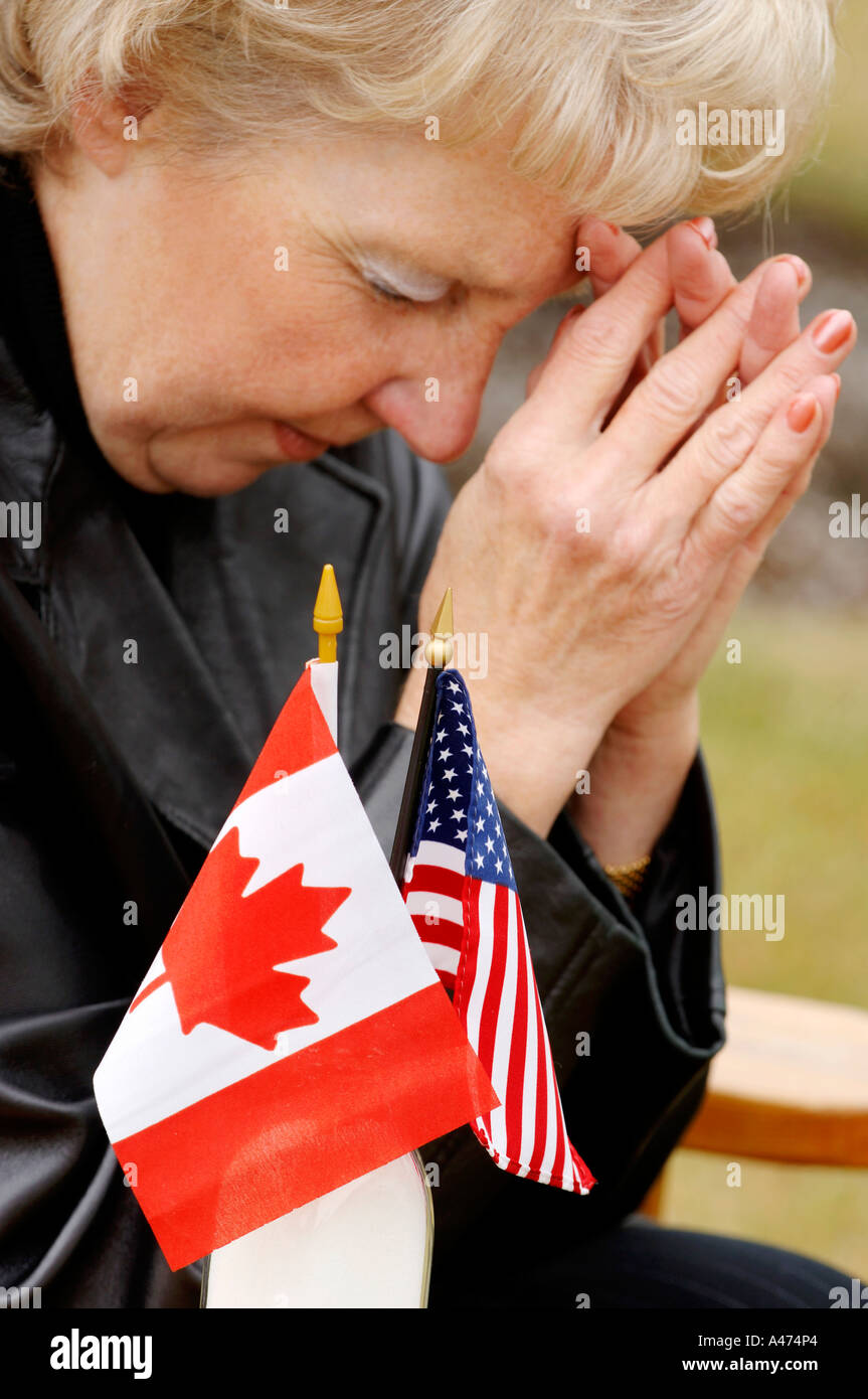 Woman praying over flags from different countries Stock Photo - Alamy
