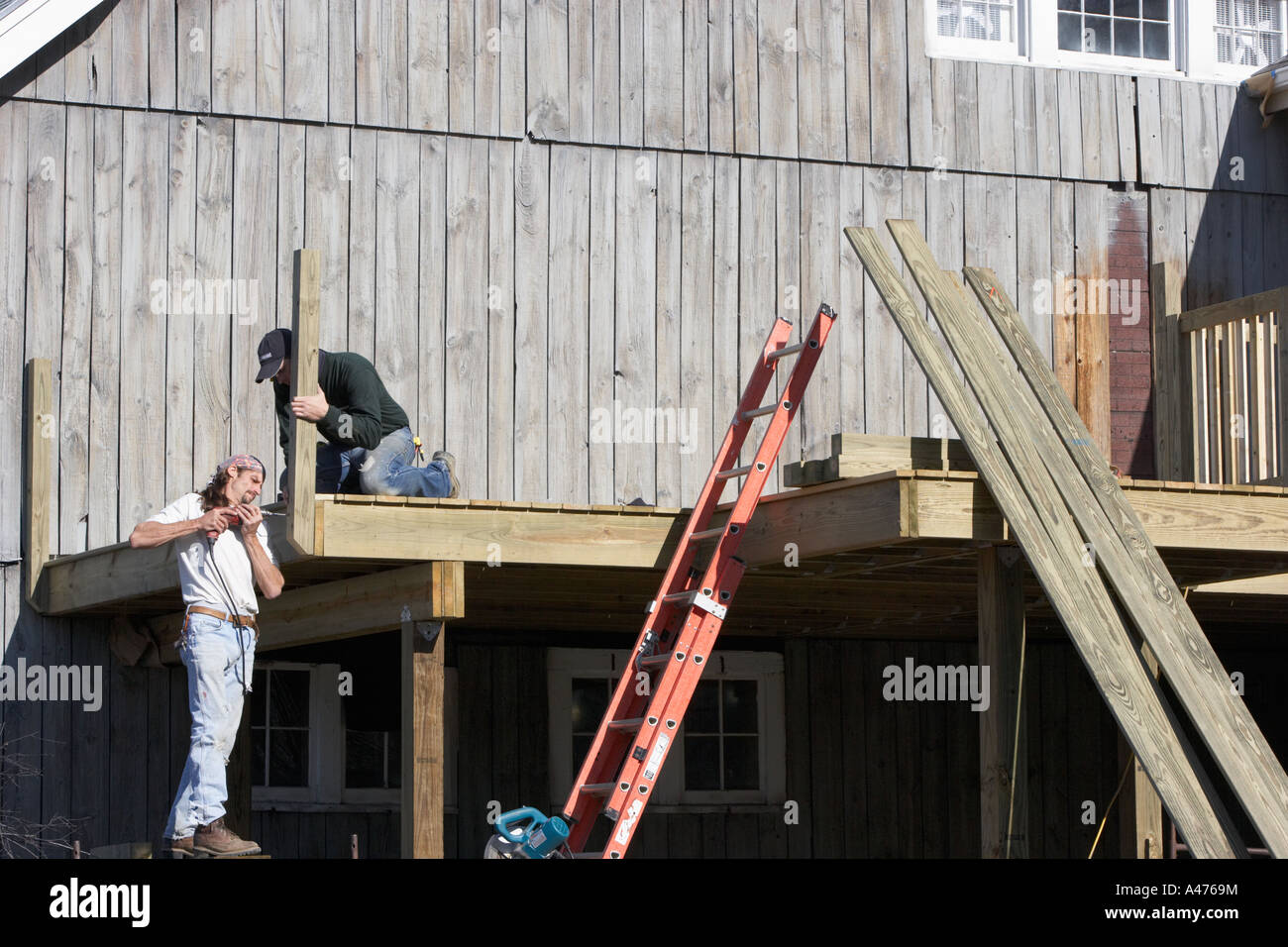 Construction workers building a deck on a residence Stock Photo - Alamy
