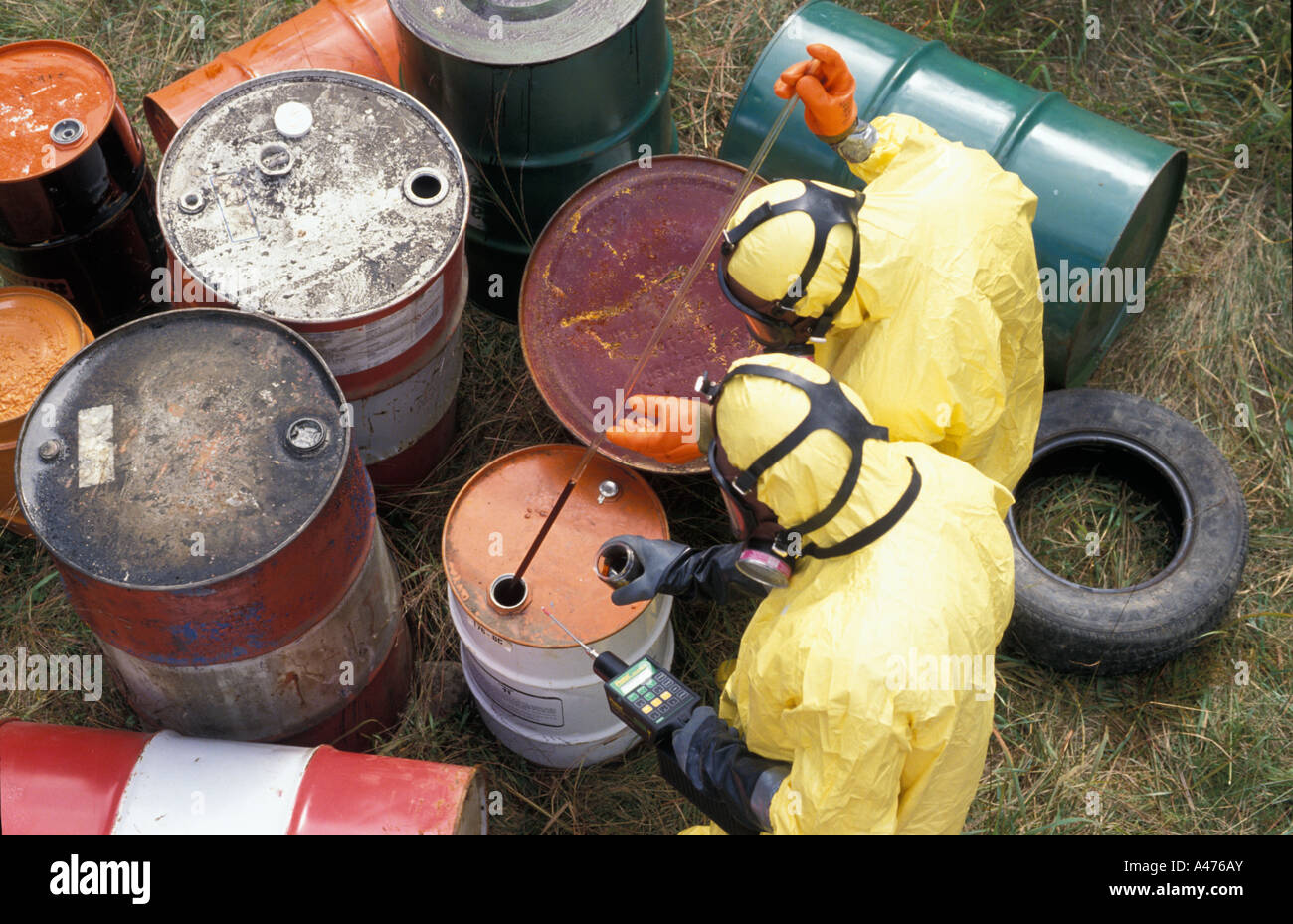 Workers in protective suits test a chemical in a metal barrel Stock ...