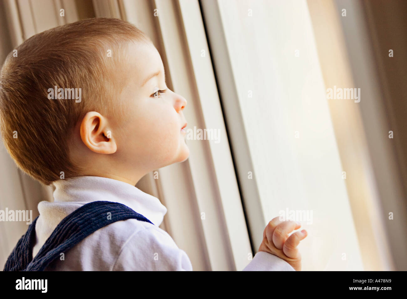 Child looks out the window Stock Photo - Alamy