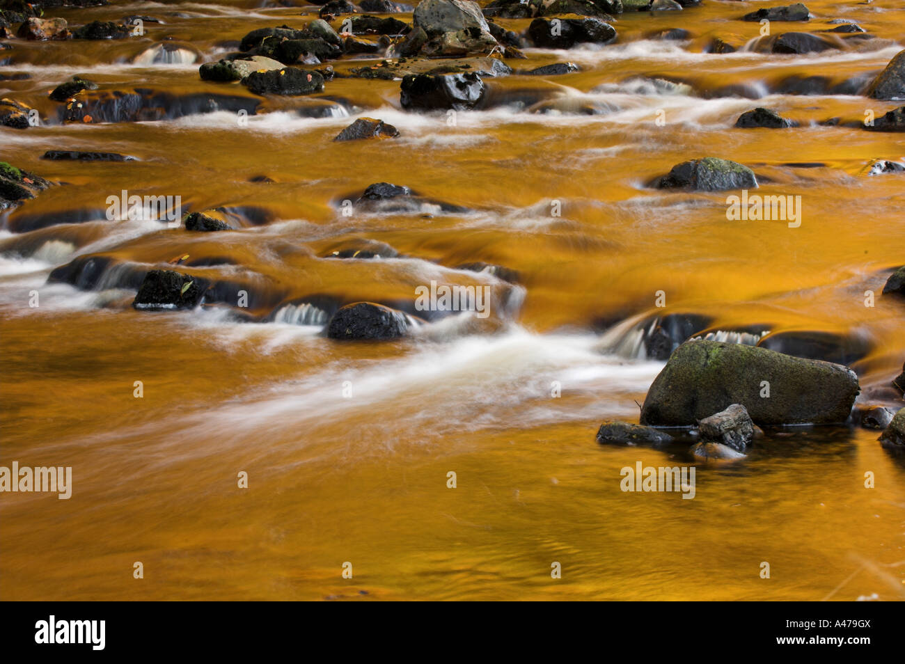 Autumn reflections on fast flowing river Stock Photo - Alamy