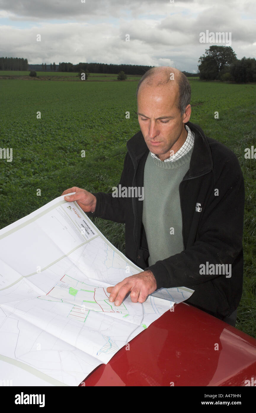Farmer looking at maps of farm Stock Photo - Alamy