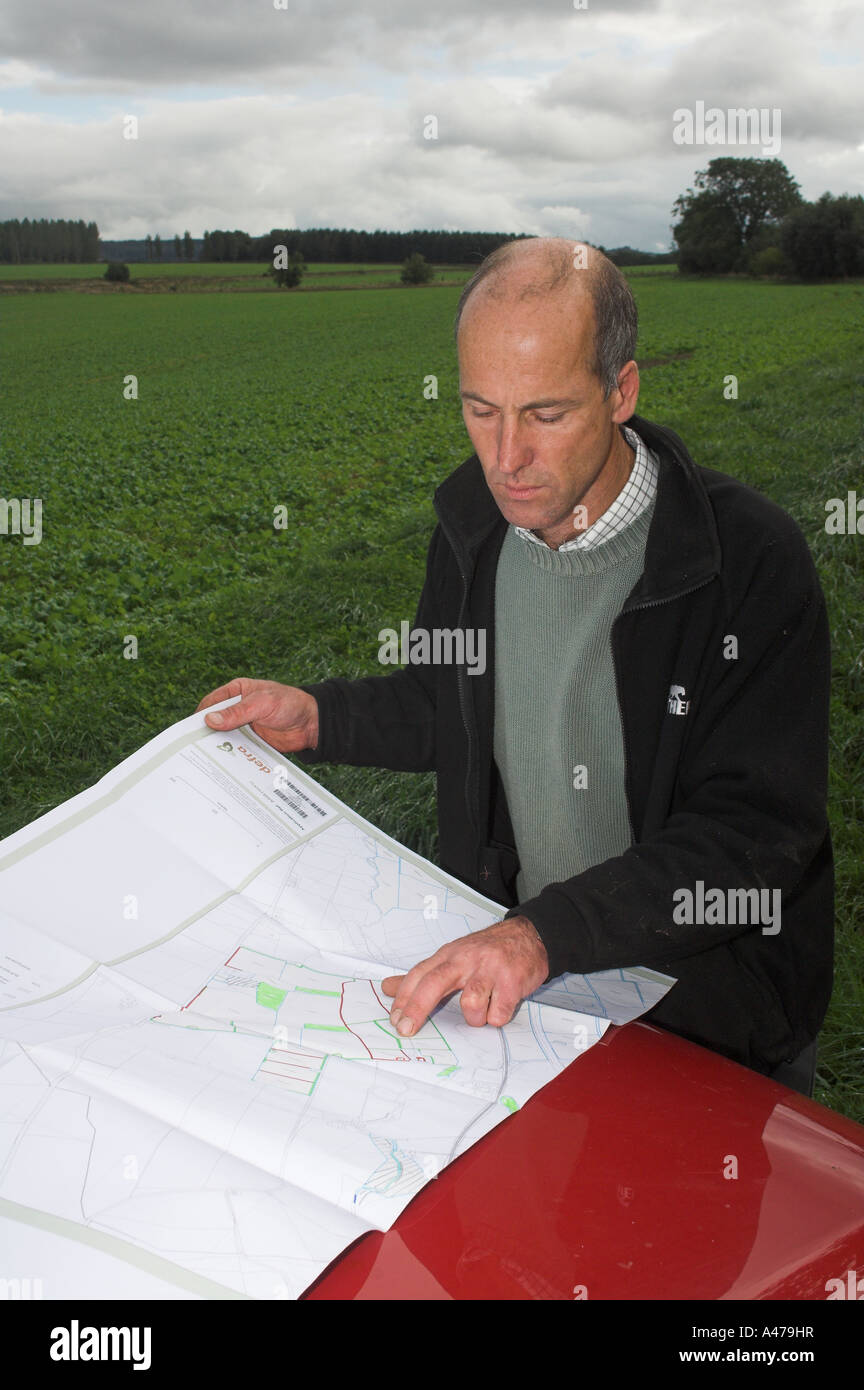 Farmer looking at maps of farm Stock Photo - Alamy