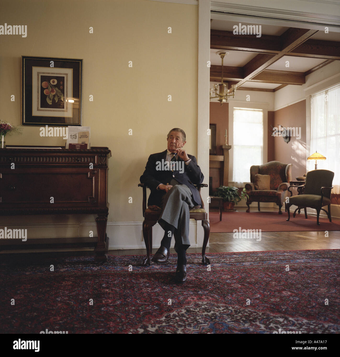 EIghty year old man sitting down in a Georgian hotel Stock Photo - Alamy