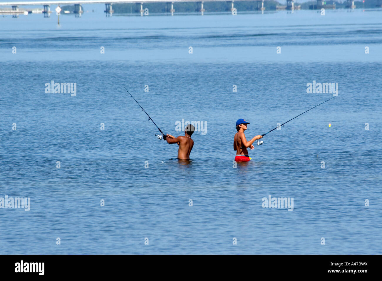 Two Boys, Back to Back, Fishing in the Gulf of Mexico Stock Photo - Alamy