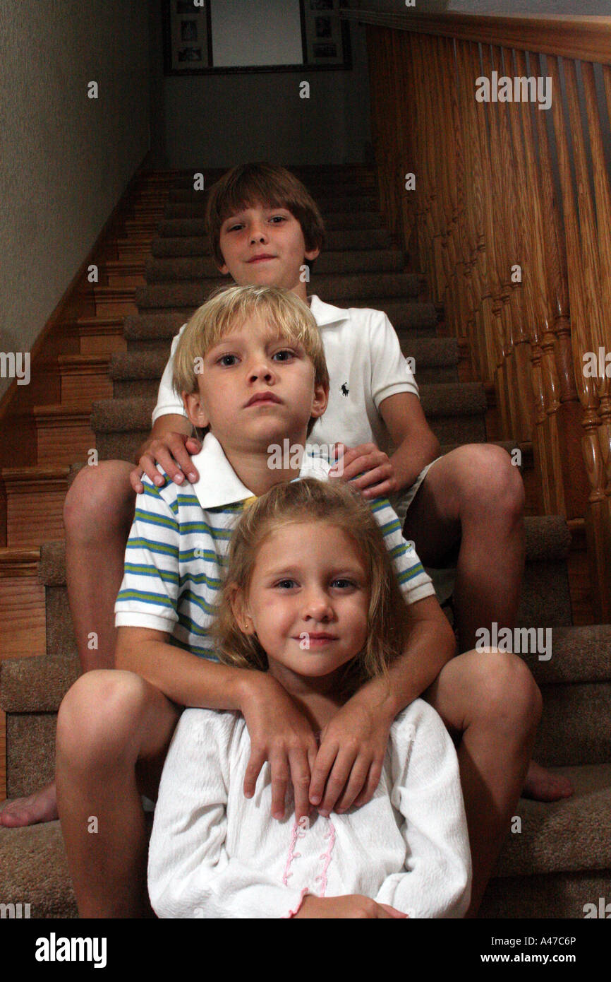 Three Children Sitting on a Staircase Stock Photo - Alamy