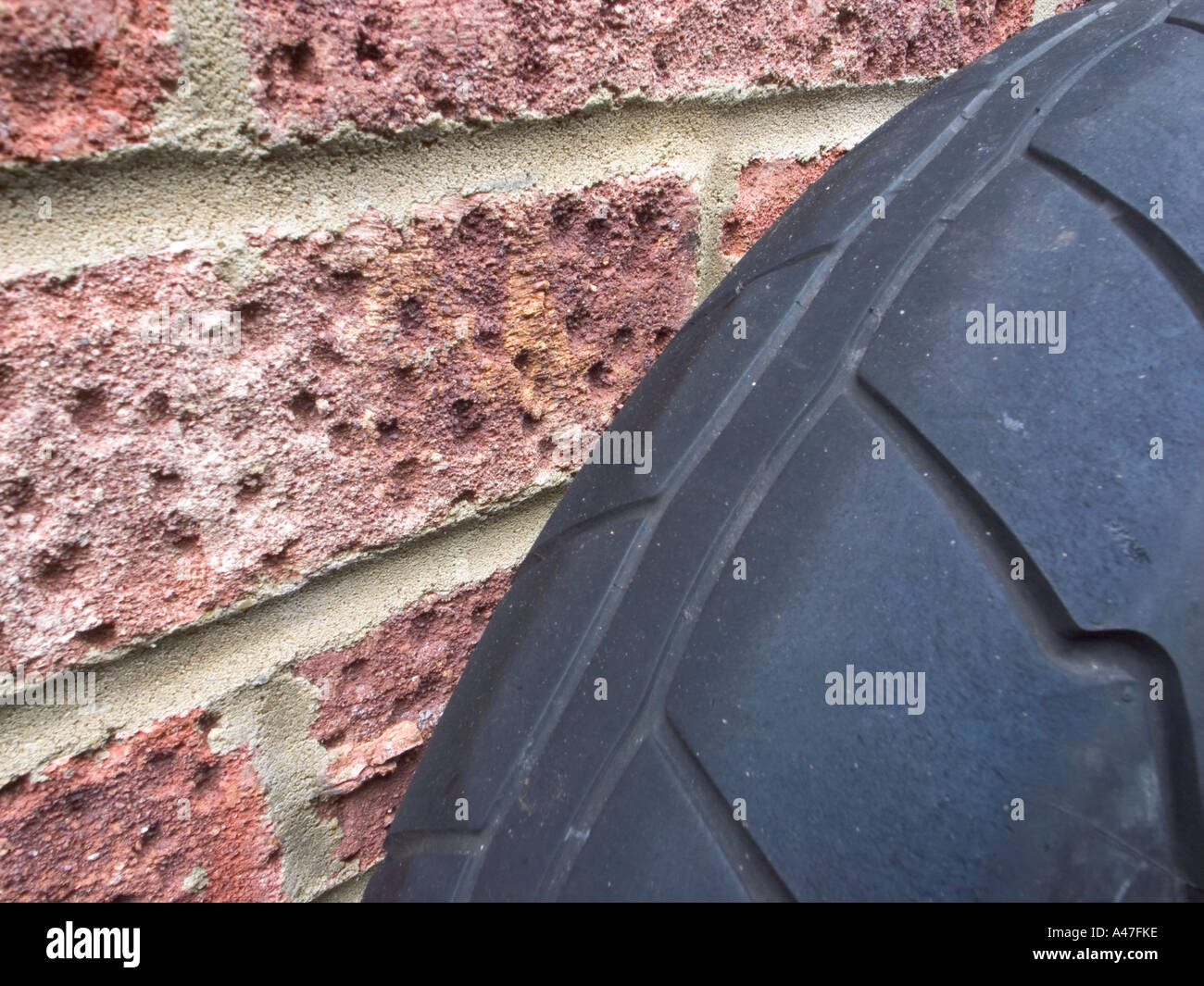 Worn motorcycle tyre leaning against a brick wall Broadstairs Kent ...