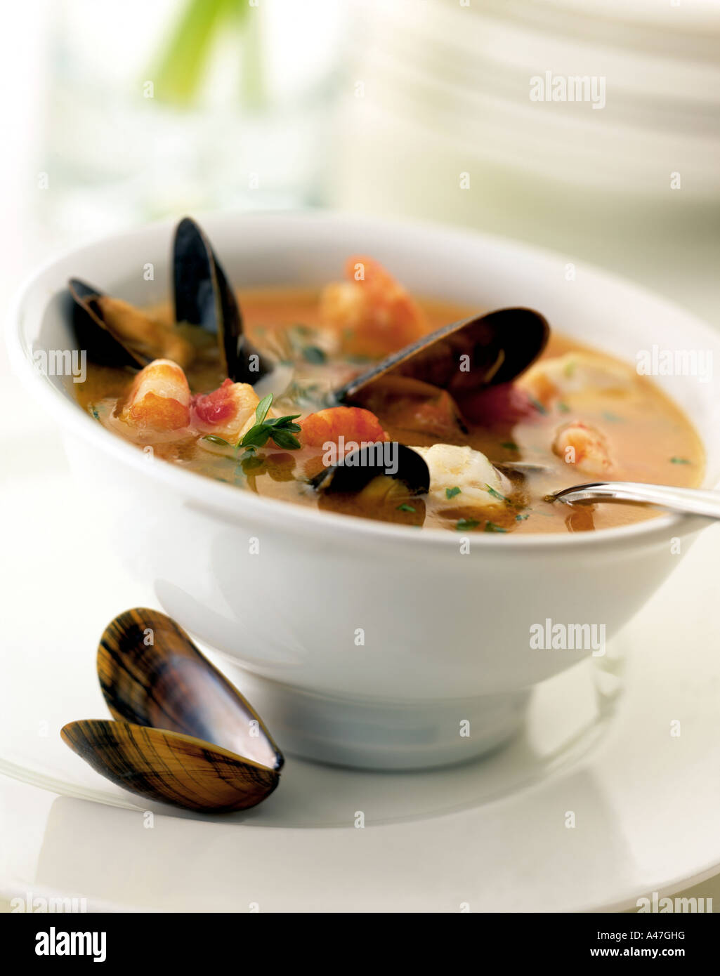 A bowl of mussel soup in a white table setting Stock Photo - Alamy