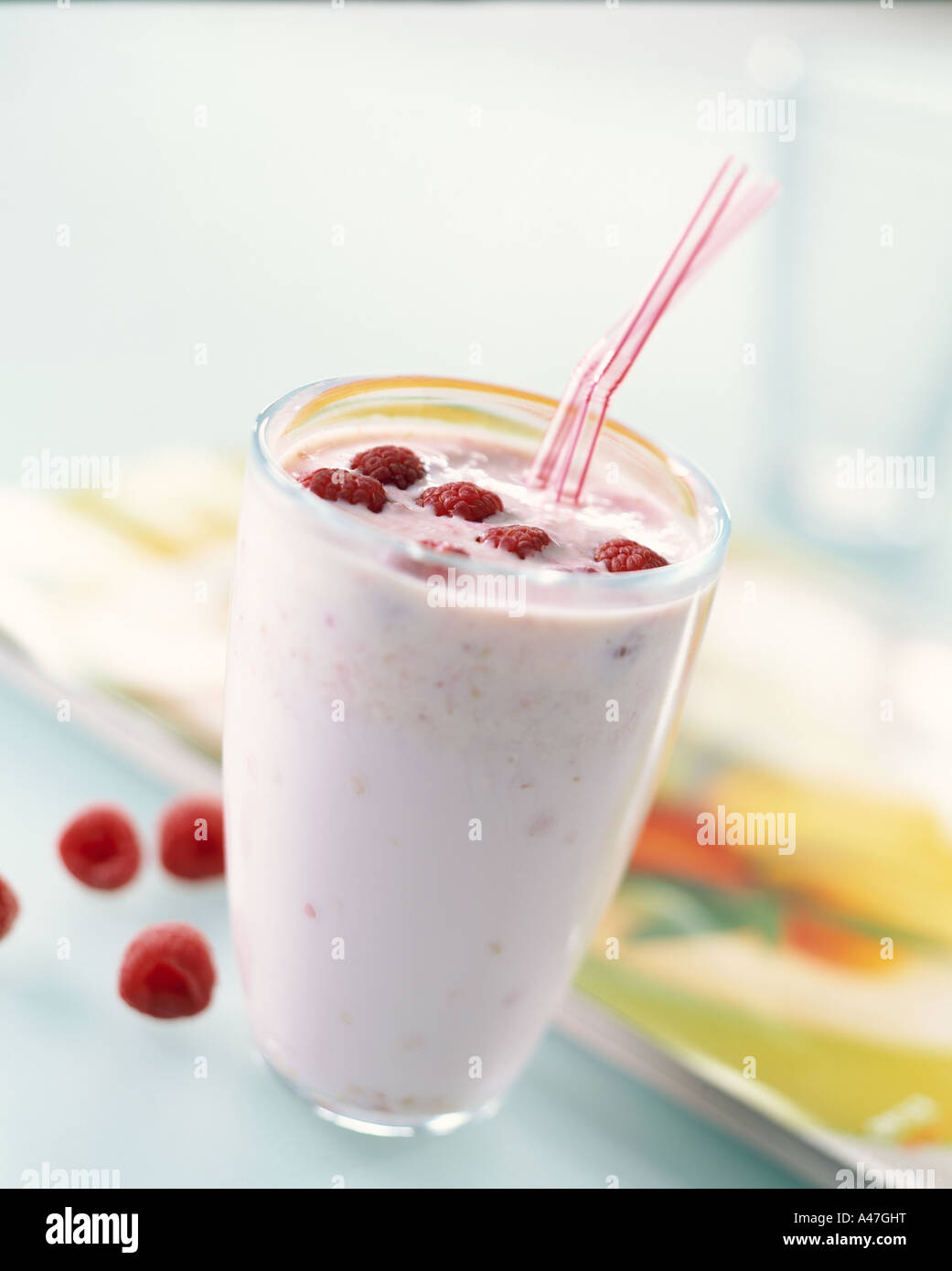 A glass of raspberry smoothie in a table setting vegetarian editorial ...