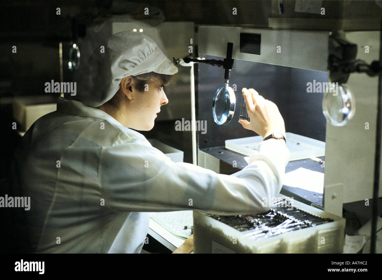 An operator examining products at a quality contol check at Boots ...
