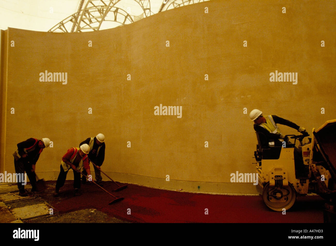 construction workman leveling pathway using rakes mini roller inside ...