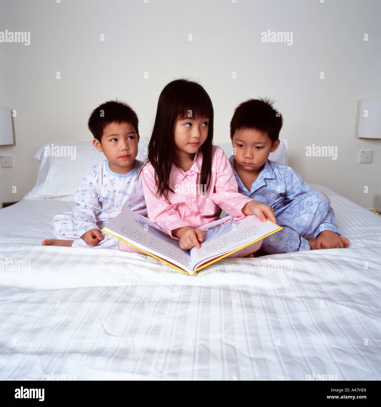 Children on bed with book Stock Photo - Alamy