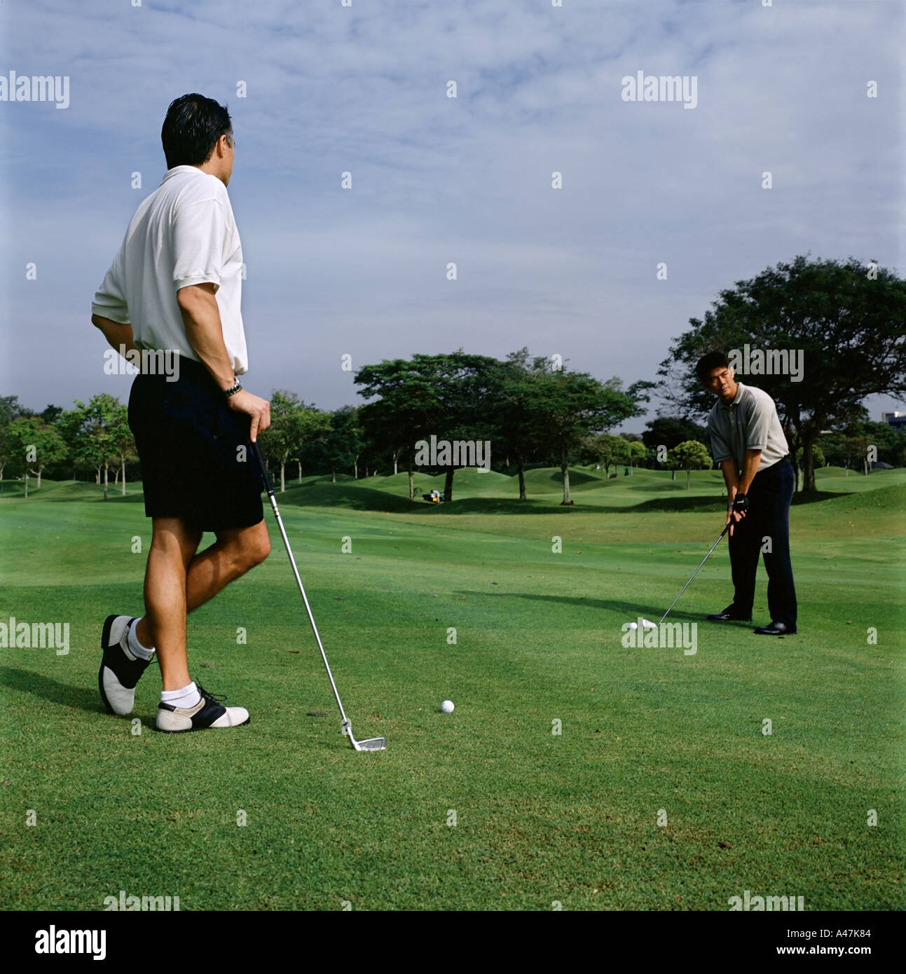 Two men playing golf Stock Photo - Alamy