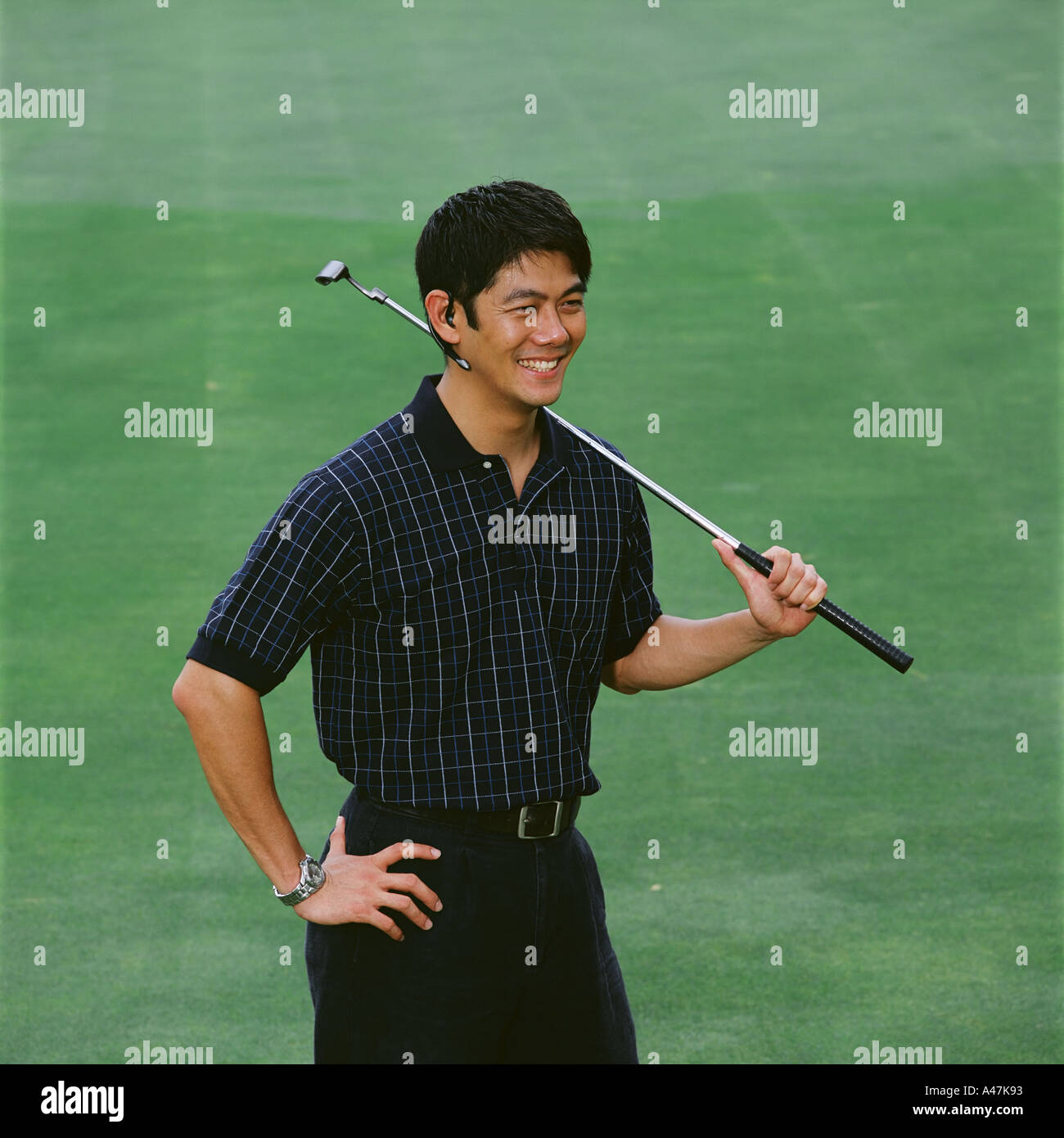 Man on golf green with bluetooth headset Stock Photo - Alamy