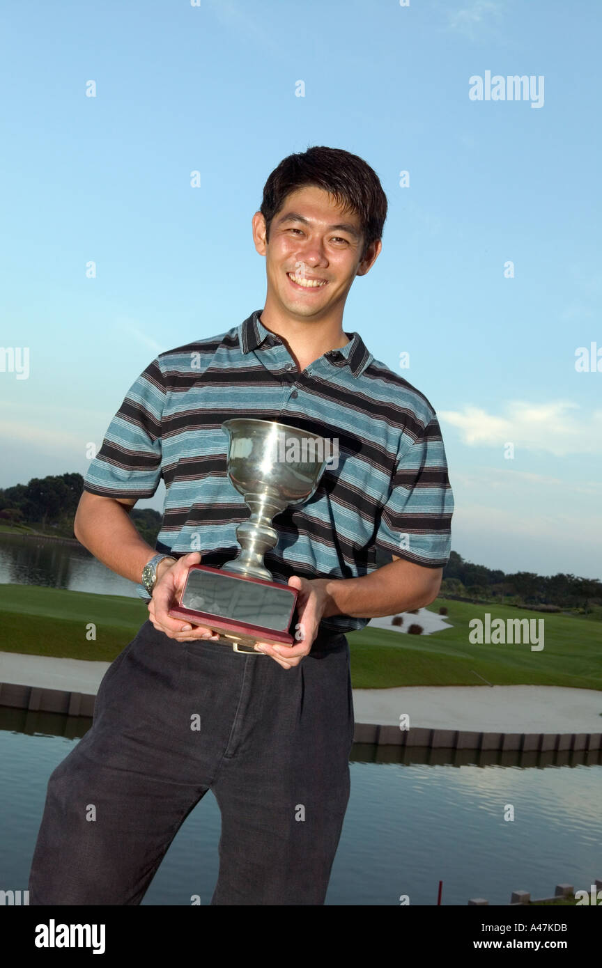 Asian man holding a trophy Stock Photo - Alamy