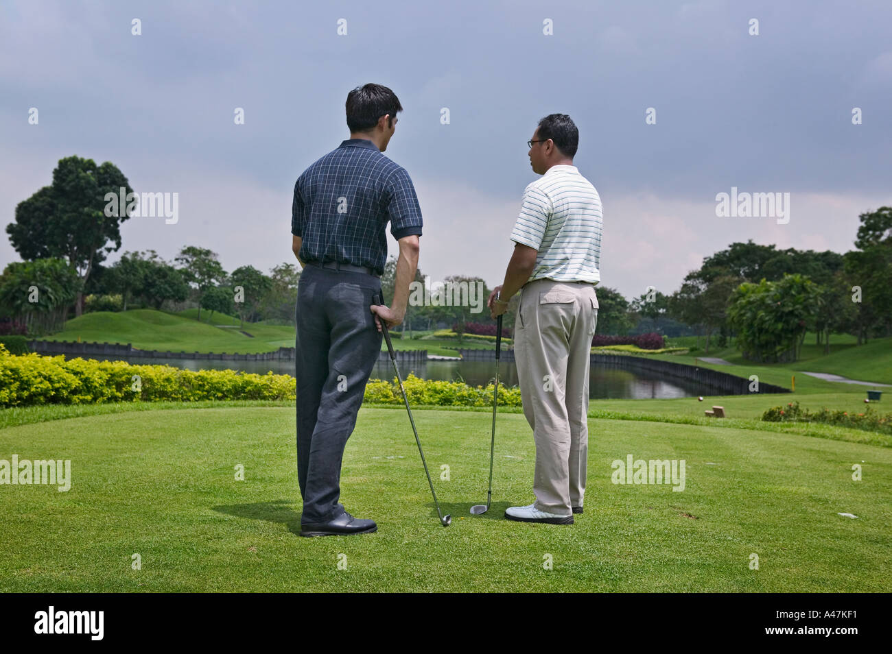 Two men playing golf Stock Photo - Alamy