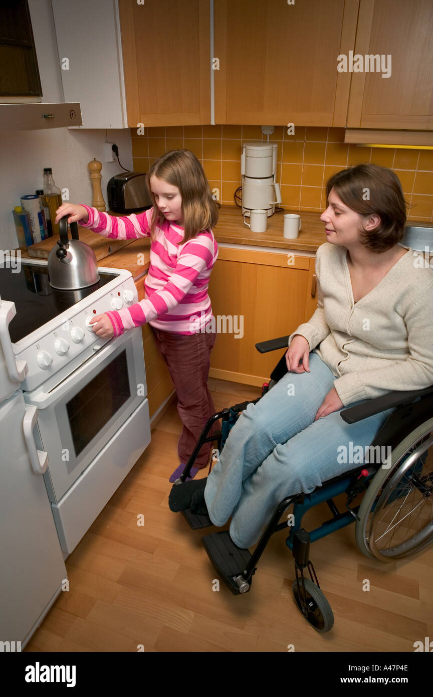 Disabled mother and daughter in kitchen Stock Photo - Alamy