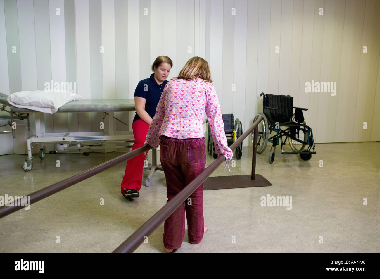 Girl walking using support bars Stock Photo - Alamy