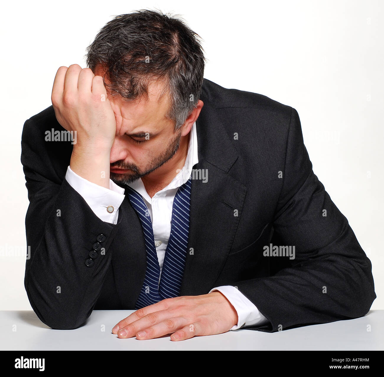 An emotional man sits holding his head with his hands. Picture by ...