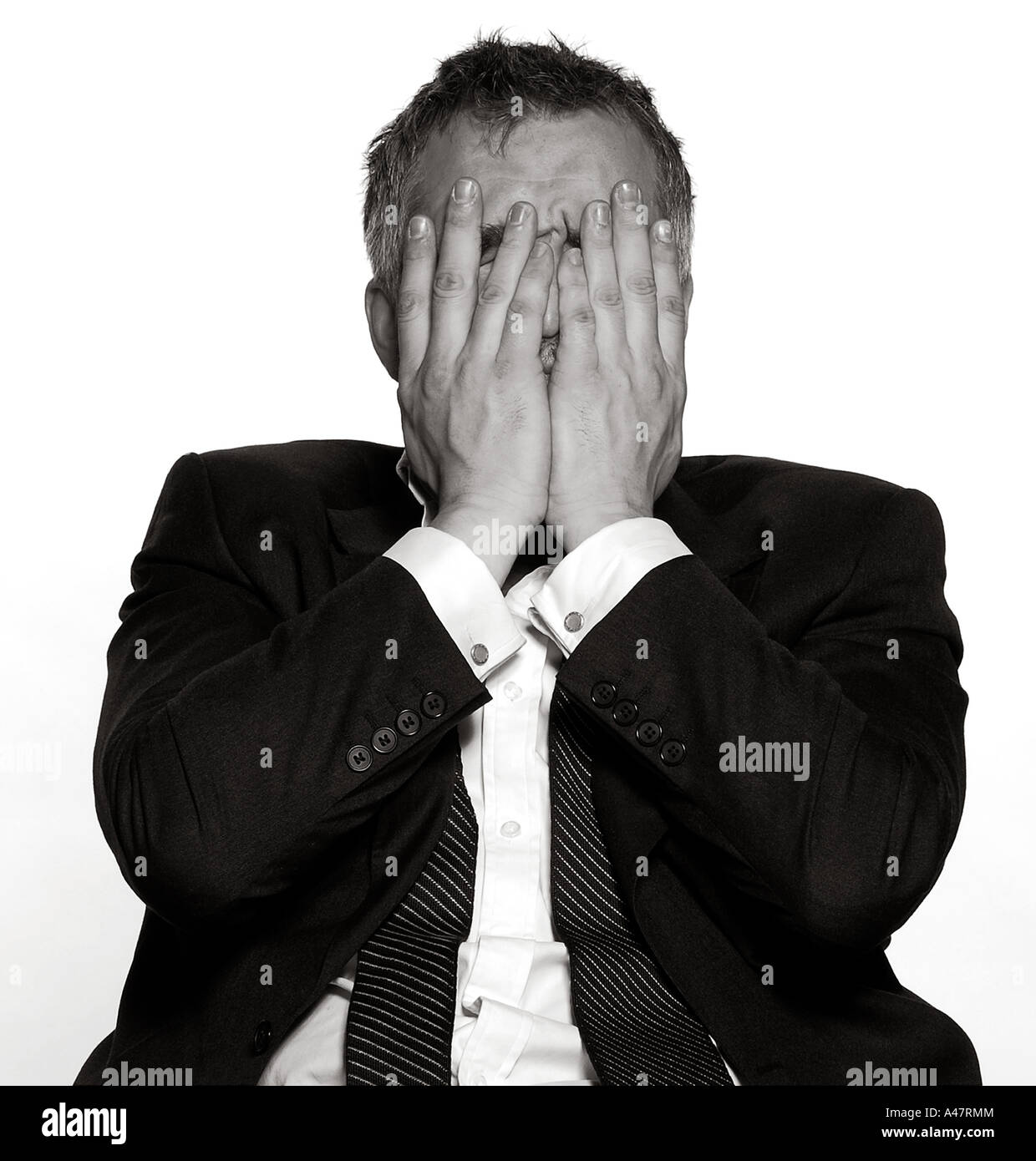 An emotional man sits holding his head with his hands. Picture by ...