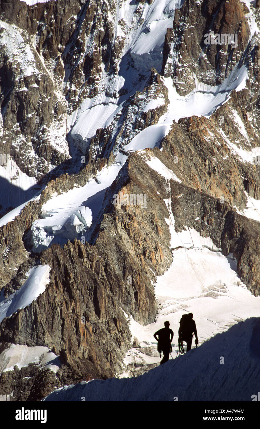 Two climbers silhouetted on a ridge high in the French Alps Stock Photo ...