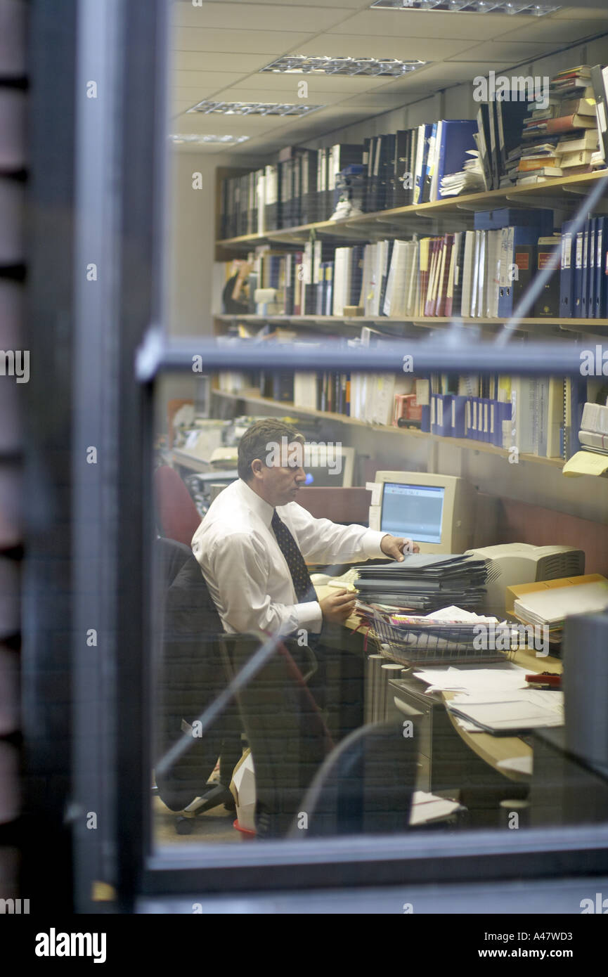 Looking though a window of a Man working at a compter in solicitors ...
