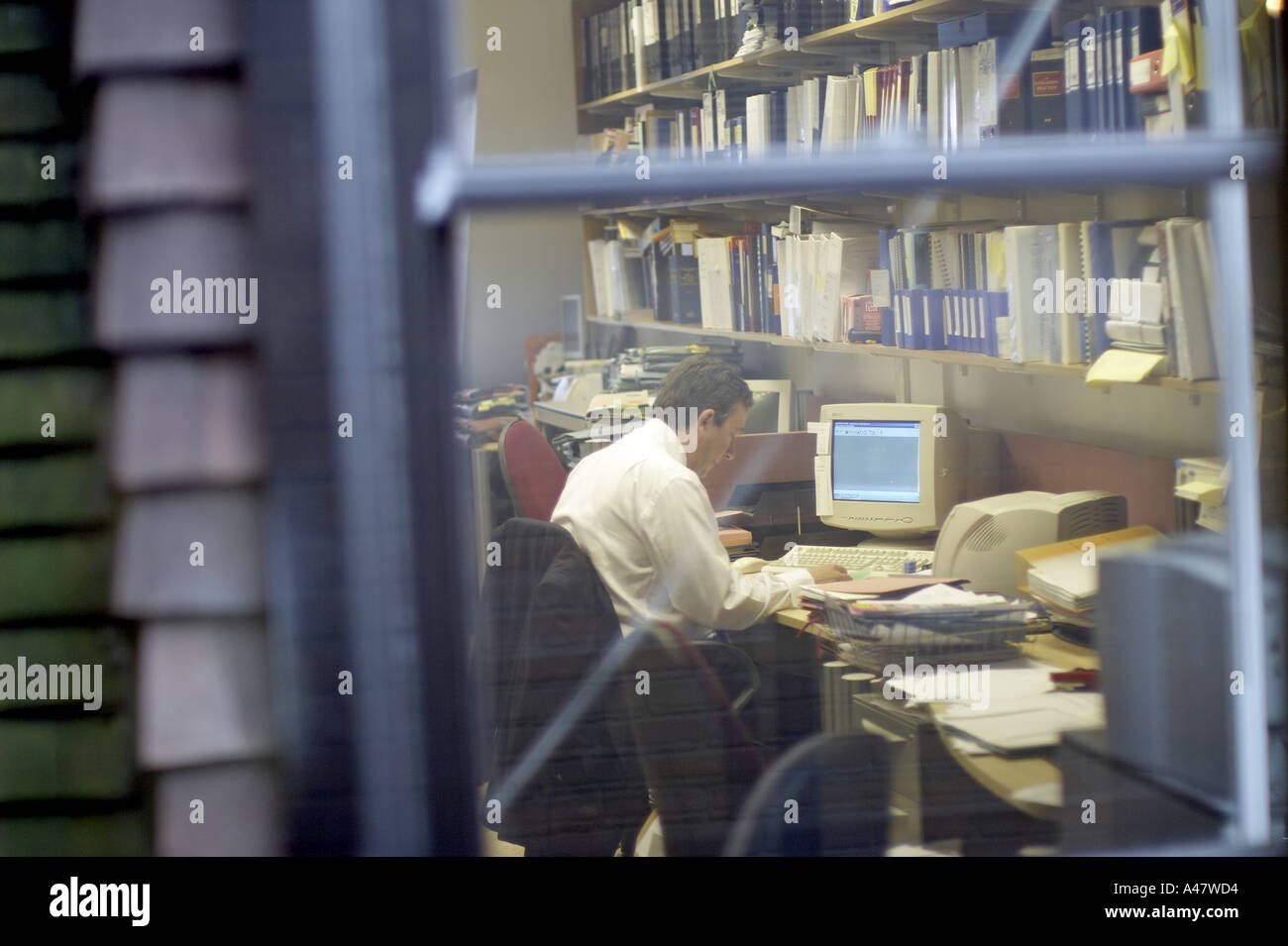 Looking though a window of a Man working at a compter in solicitors ...