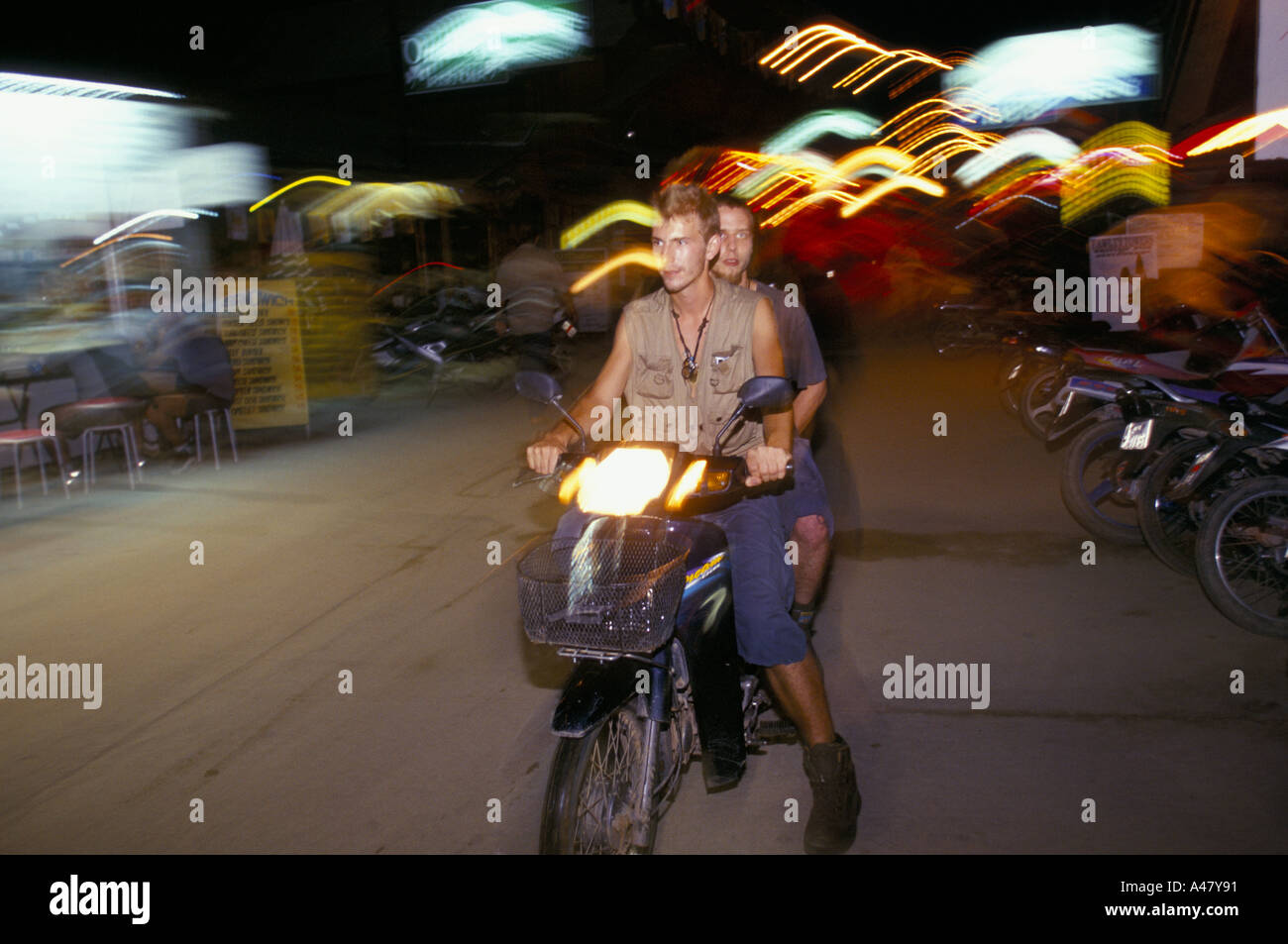 Two Western travellers on a moped ride through the resort town of koh ...