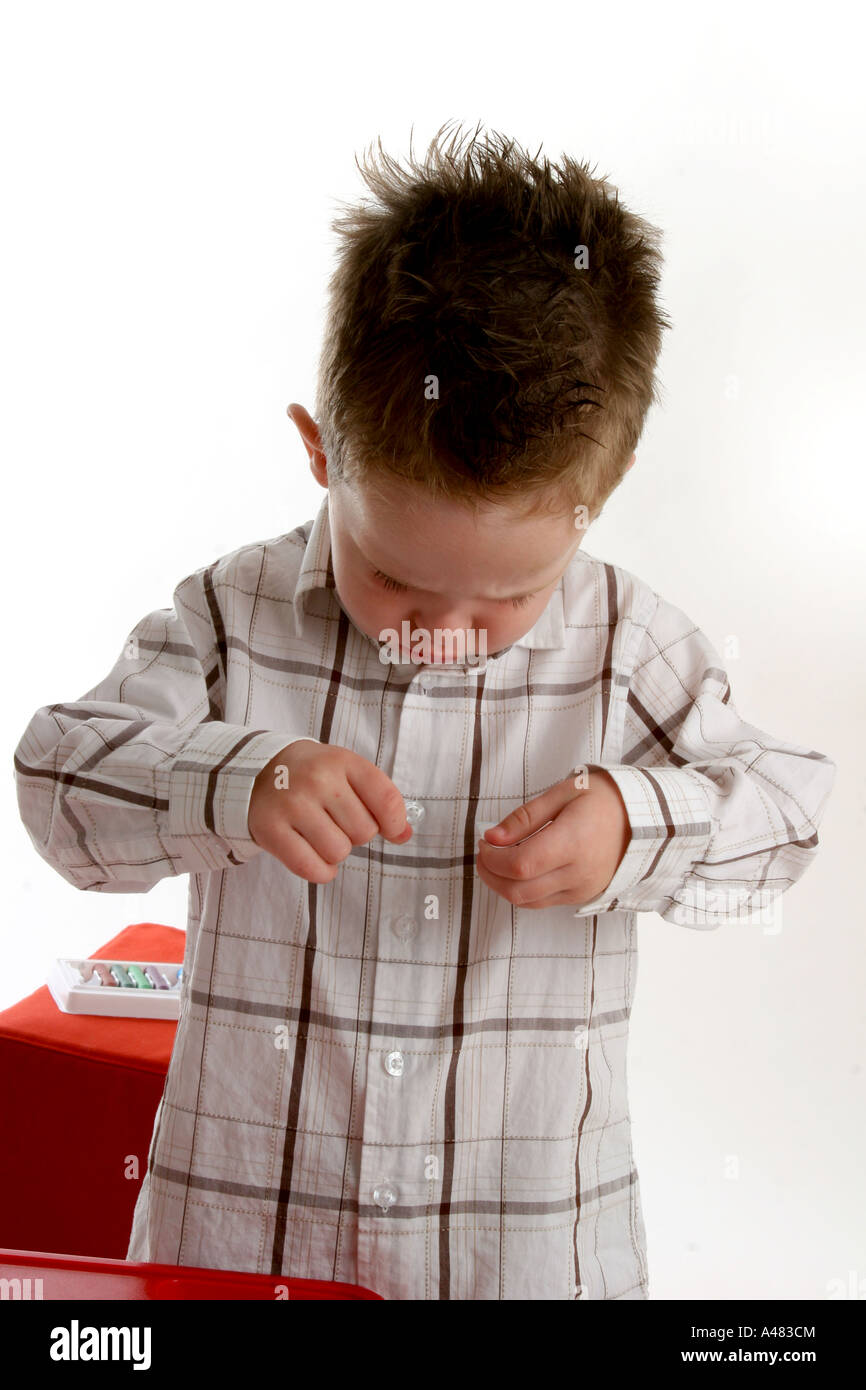 Young boy concentrating on a small task Stock Photo - Alamy