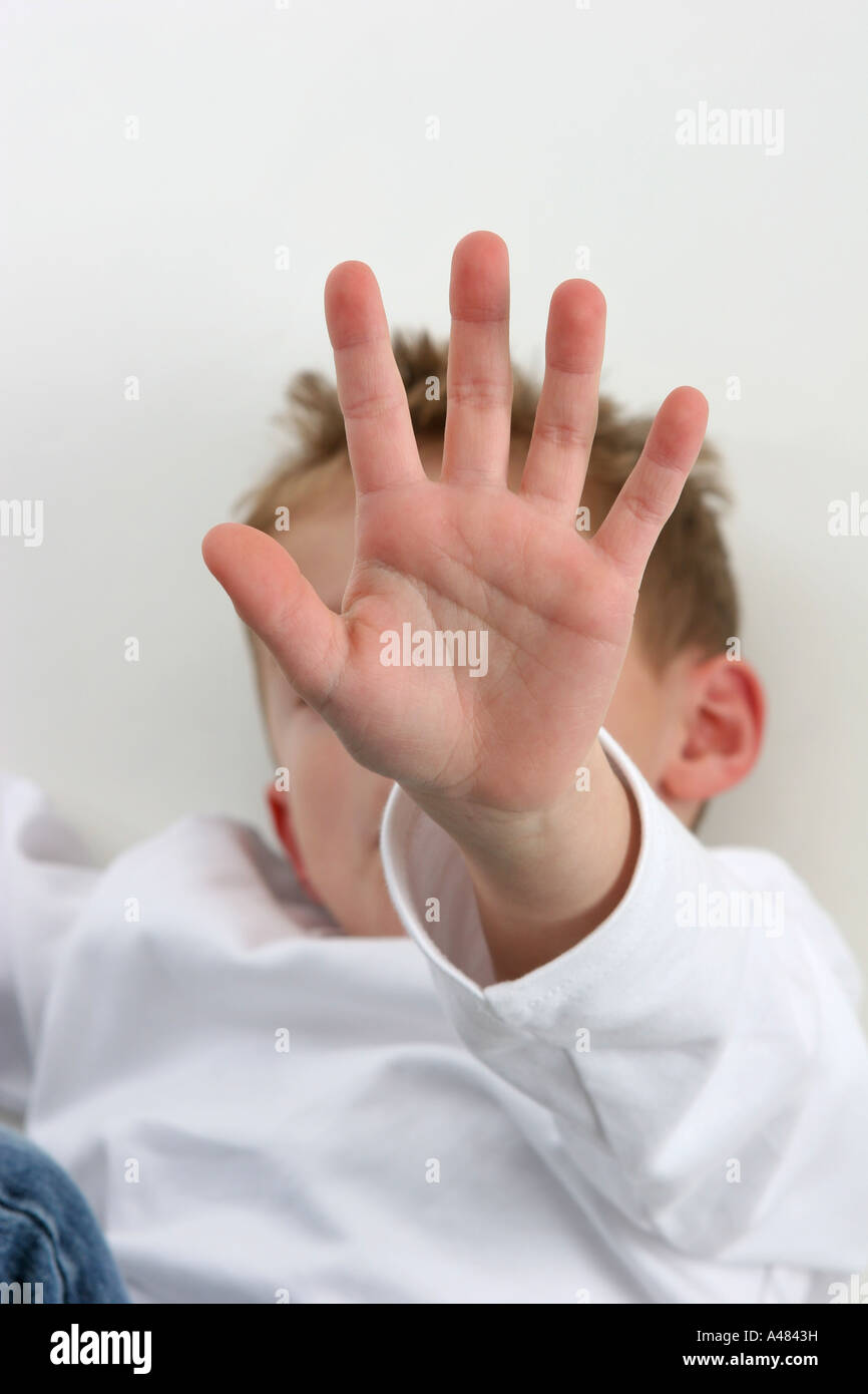 Boy holding out his hand protecting his face from the camera Stock ...