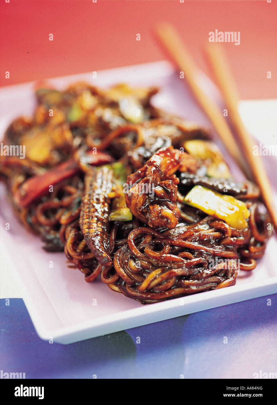 Close-up of stir-fried noodles with a pair of chopsticks on a tray ...