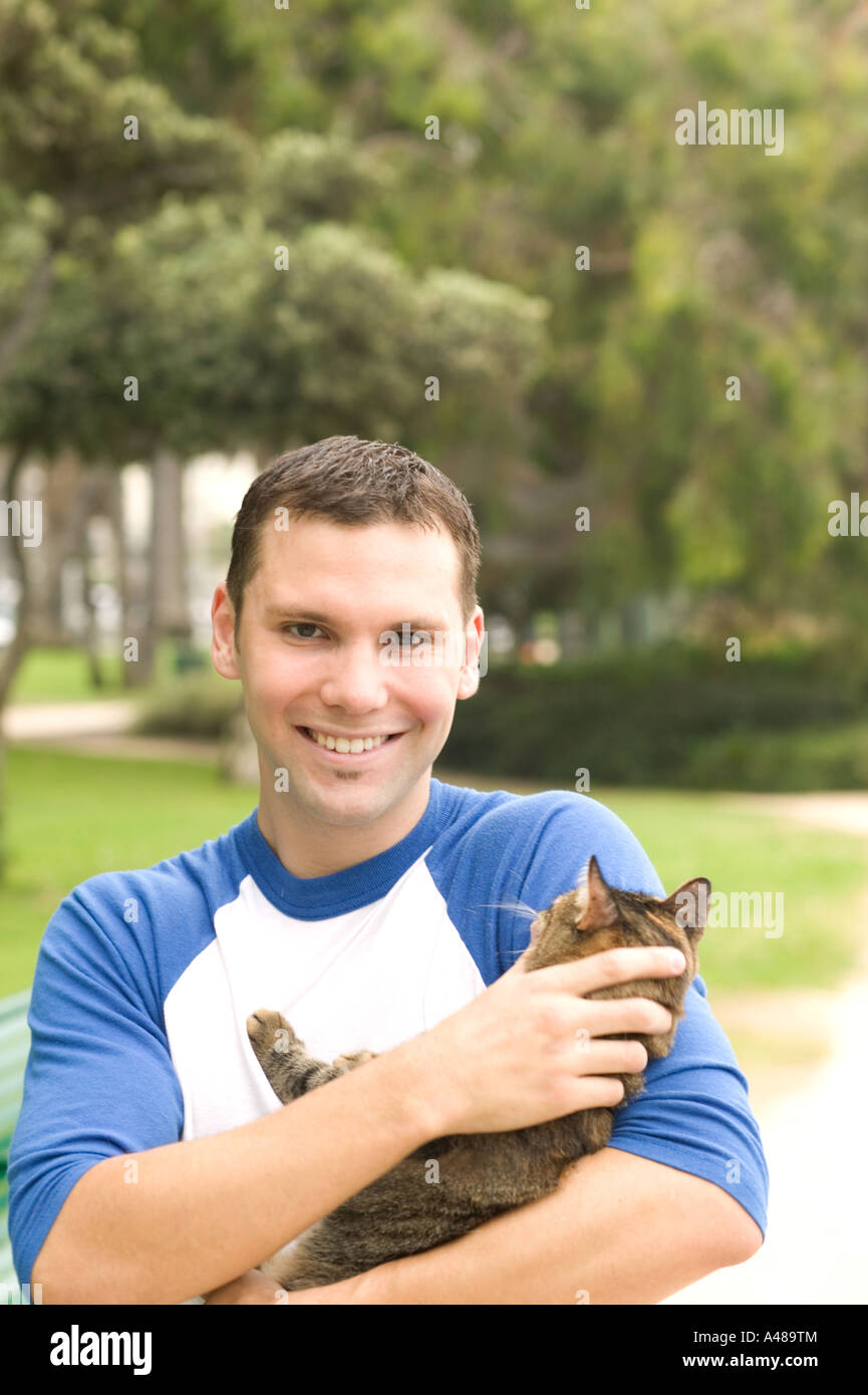 Young man carrying cat, portrait Stock Photo - Alamy