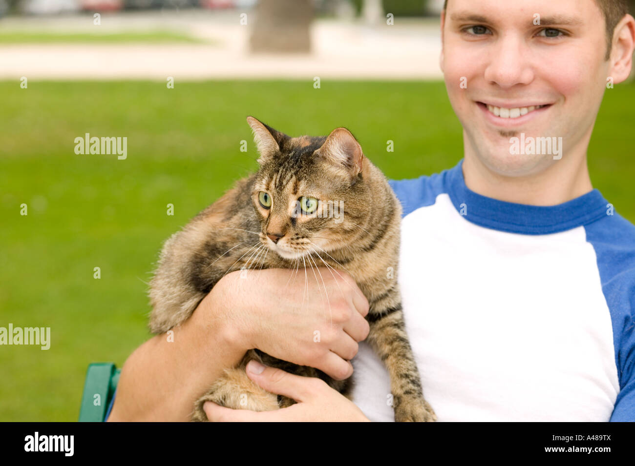 Young man carrying cat, portrait Stock Photo - Alamy