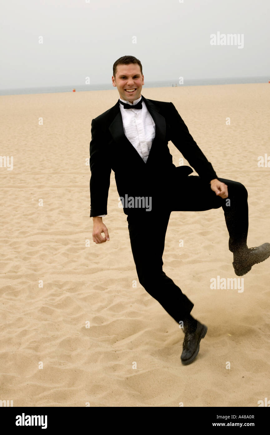 Groom jumping in joy at beach Stock Photo - Alamy