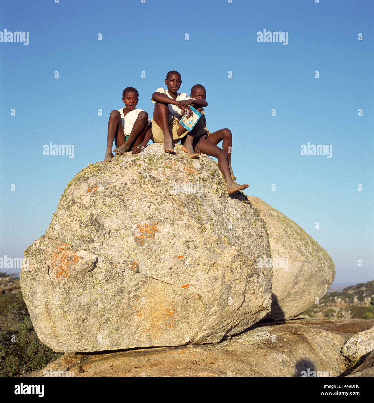 Children sitting on boulder Stock Photo - Alamy