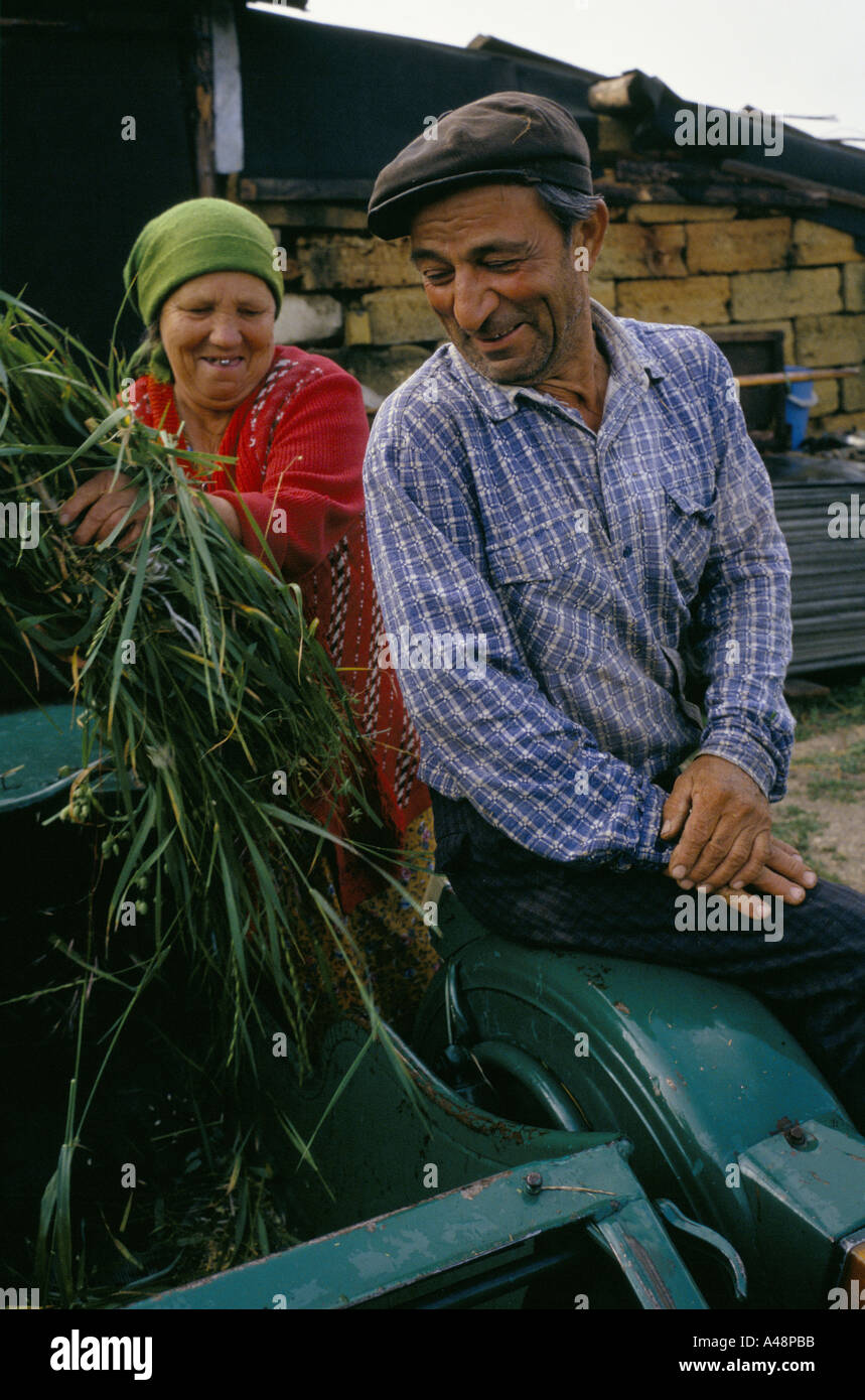 A tartar man and women on their farm with baling machine.Simferipol ...