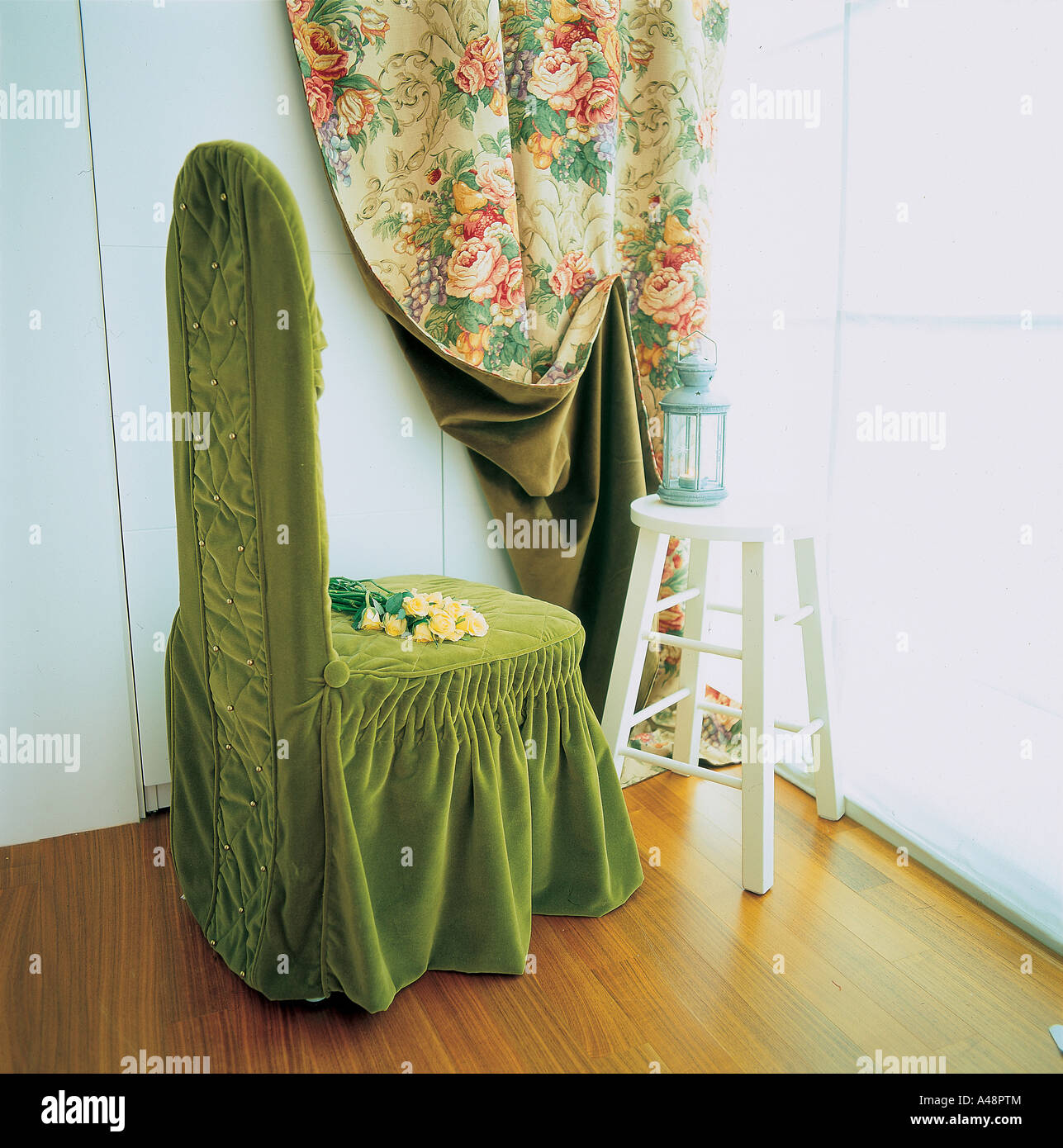 Lantern on a stool beside a chair Stock Photo - Alamy