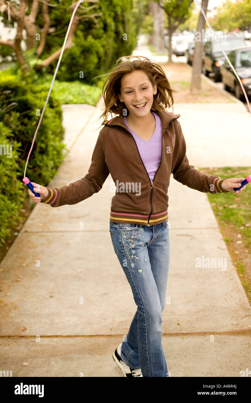 Girl skipping rope in garden, smiling Stock Photo - Alamy