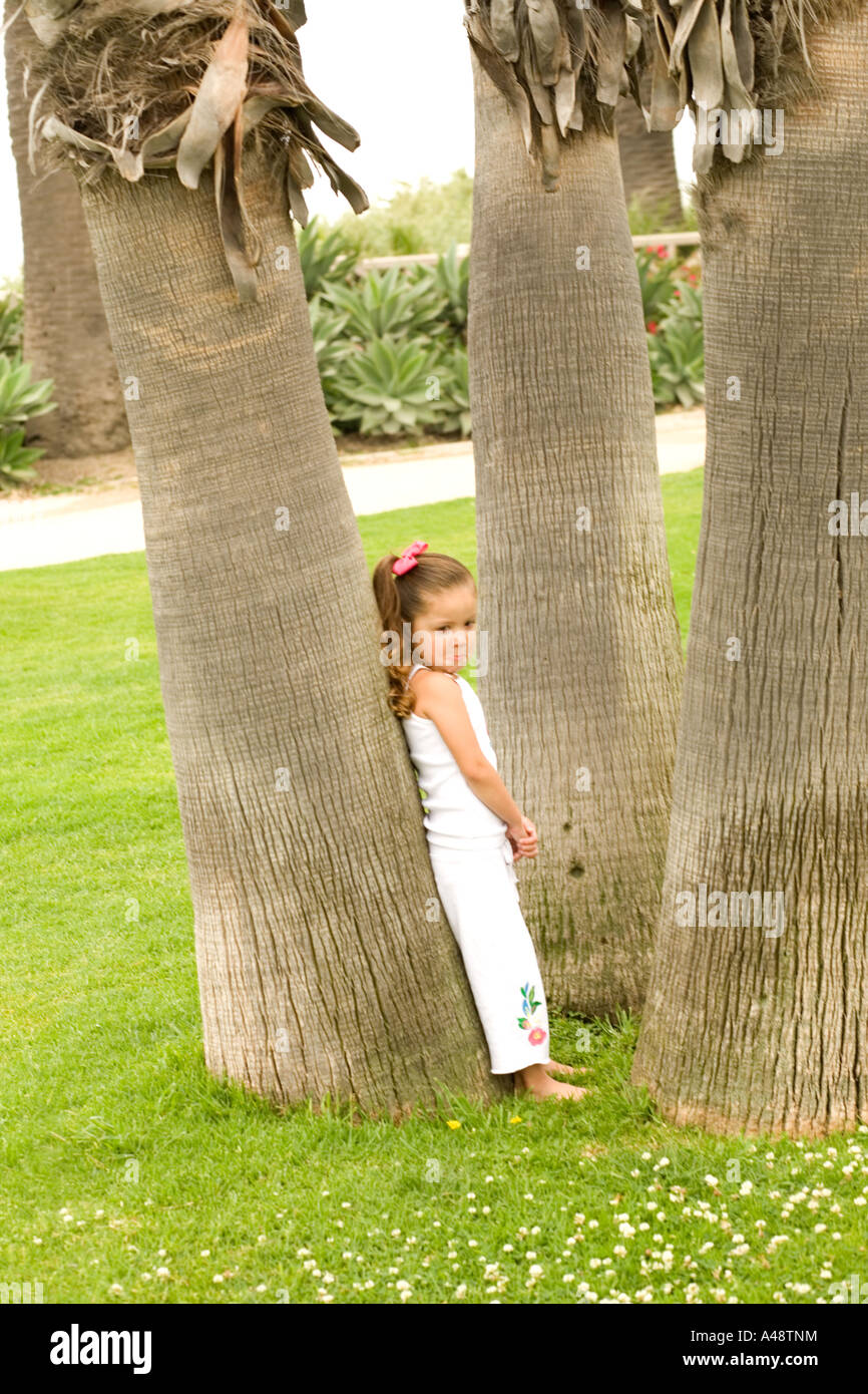 Girl (2-3) leaning on tree trunk Stock Photo - Alamy