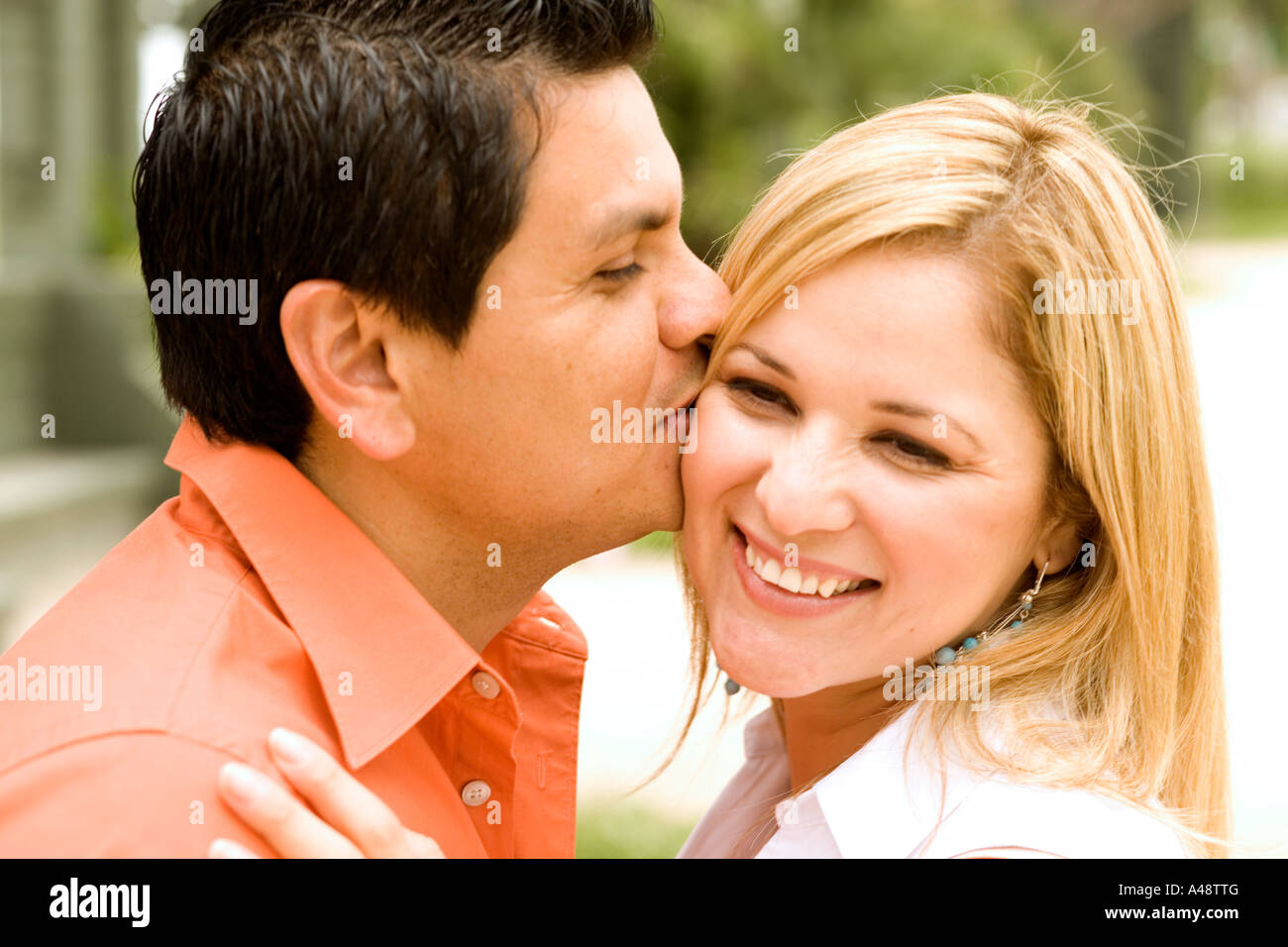 Mid adult man kissing woman, smiling Stock Photo - Alamy