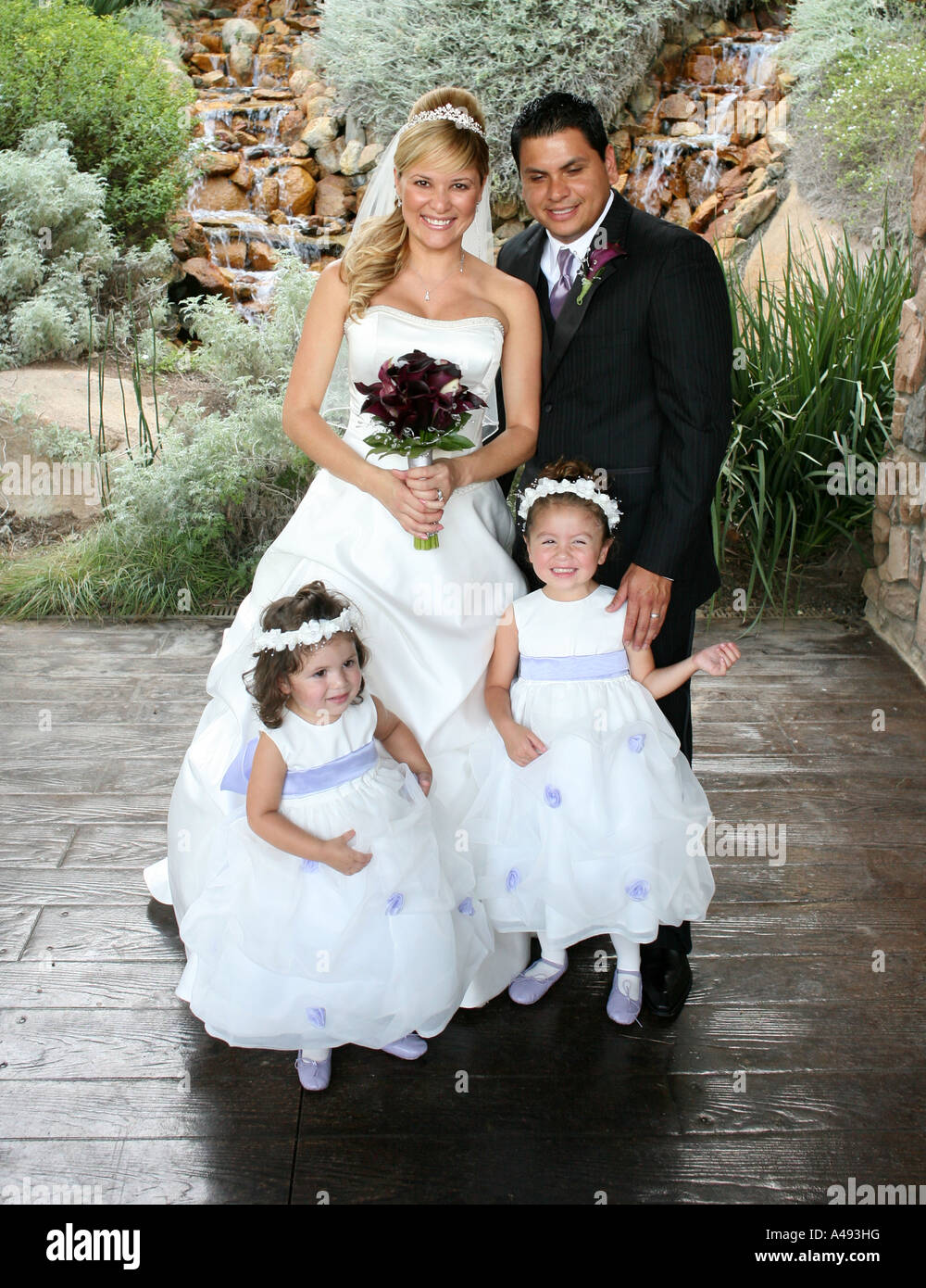 Couple standing with flower girls, portrait Stock Photo - Alamy