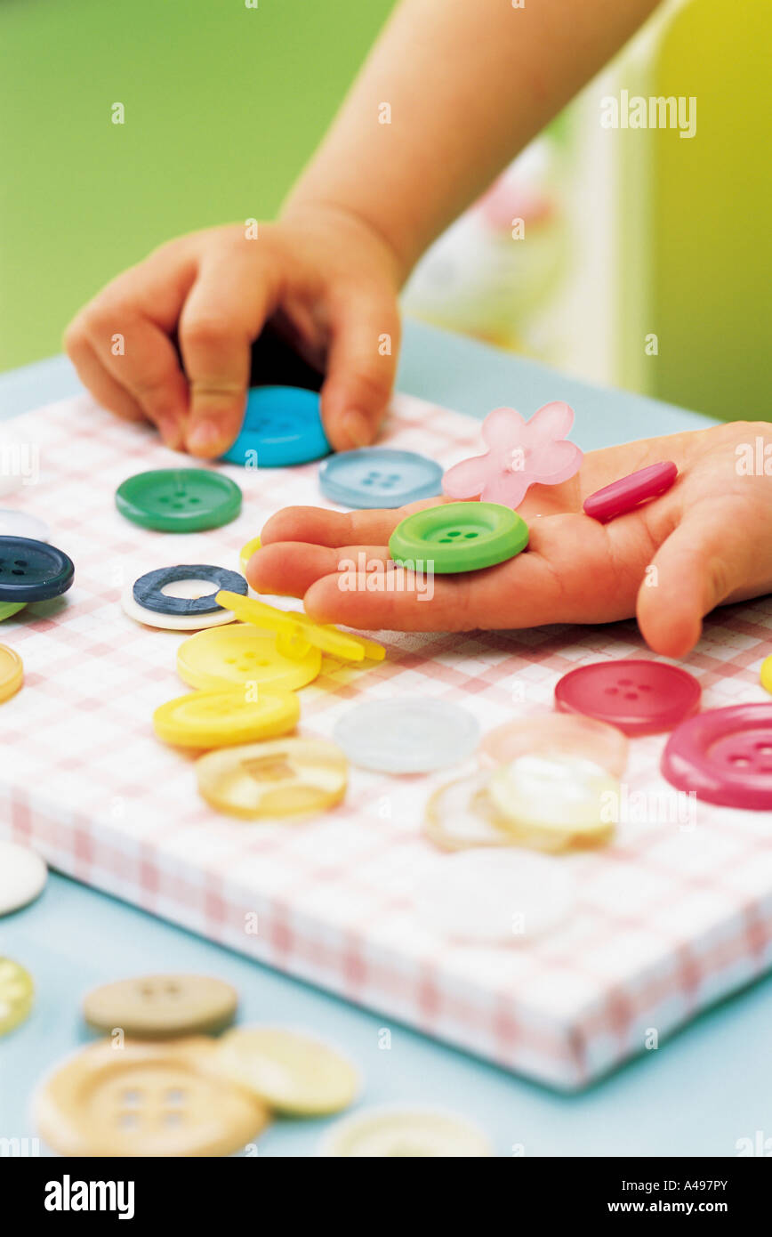 High angle view of a child's hand holding buttons Stock Photo - Alamy