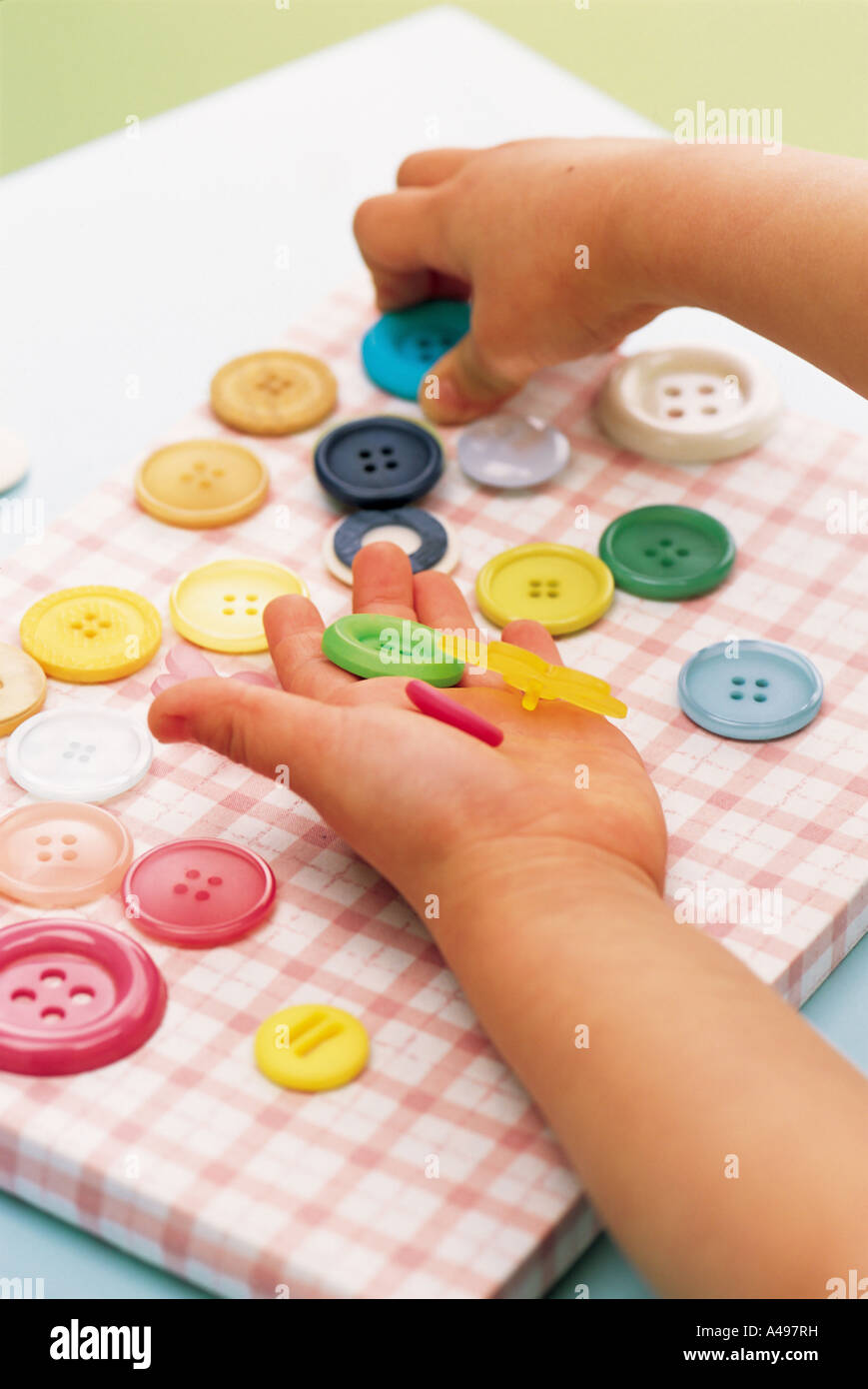High angle view of a child's hand holding buttons Stock Photo - Alamy