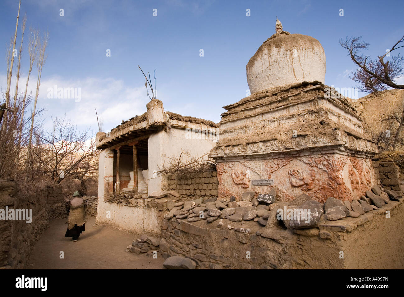 India Ladakh Leh Valley Alchi village woman walking past old votive ...