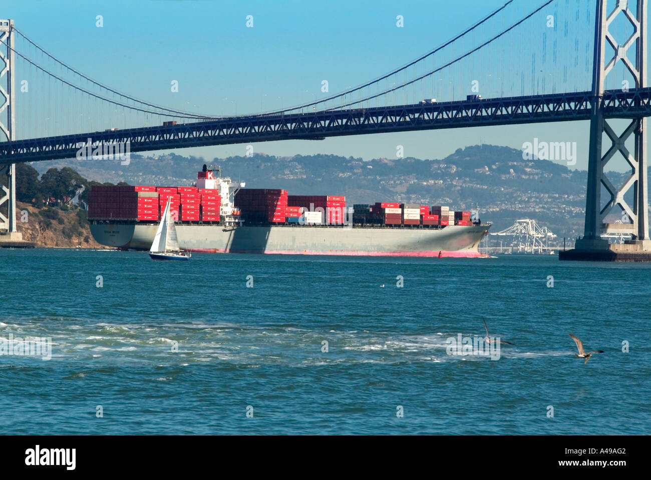 A container ship passes under the Oakland Bay Bridge in the San ...