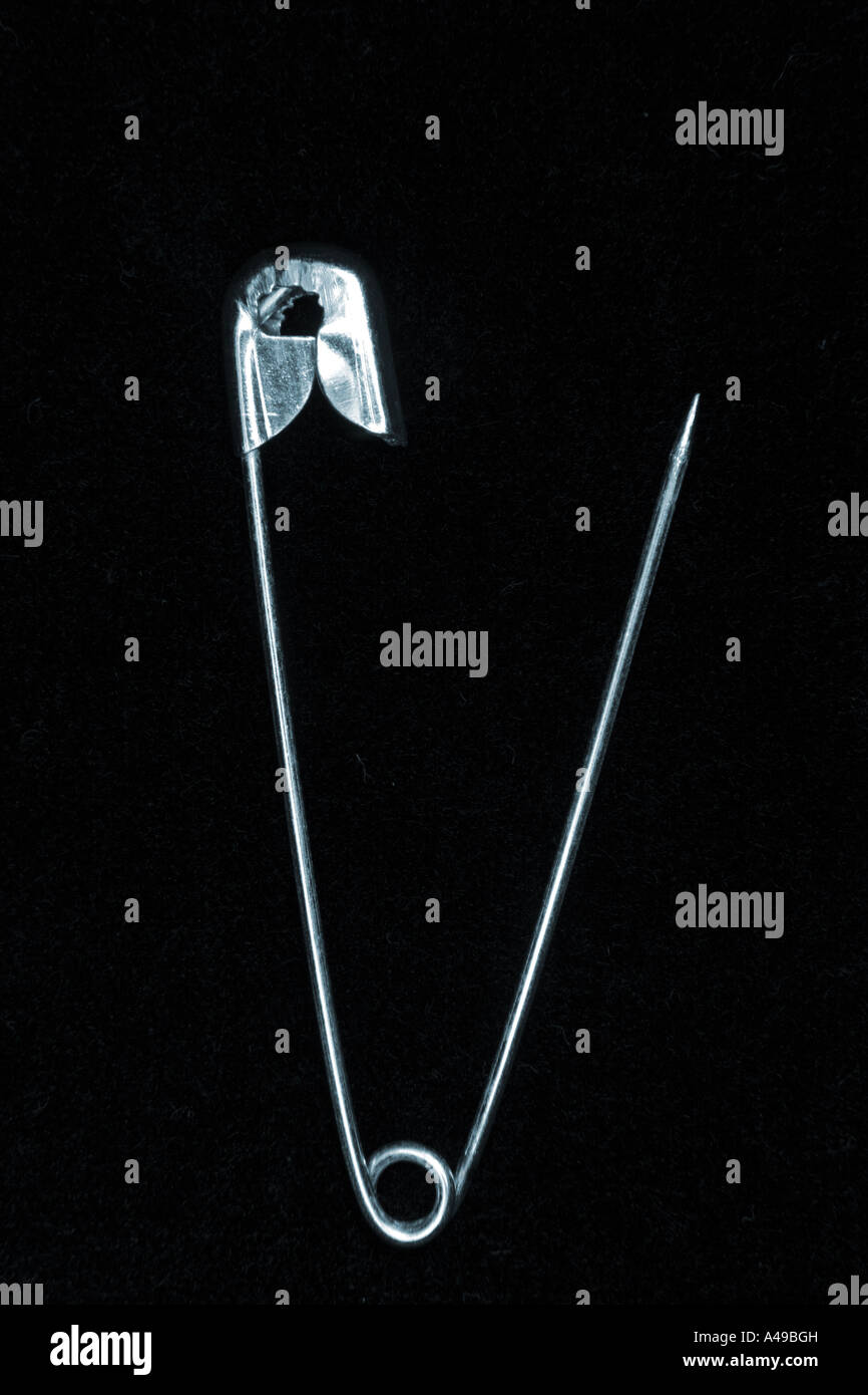 Safety pin on black background Stock Photo - Alamy
