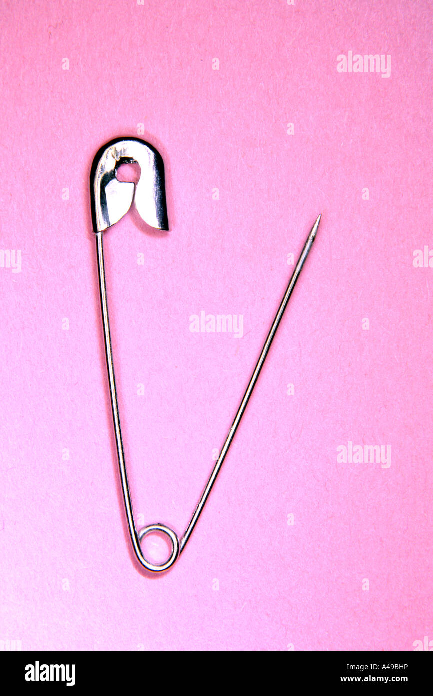 Safety pin on pink background Stock Photo - Alamy