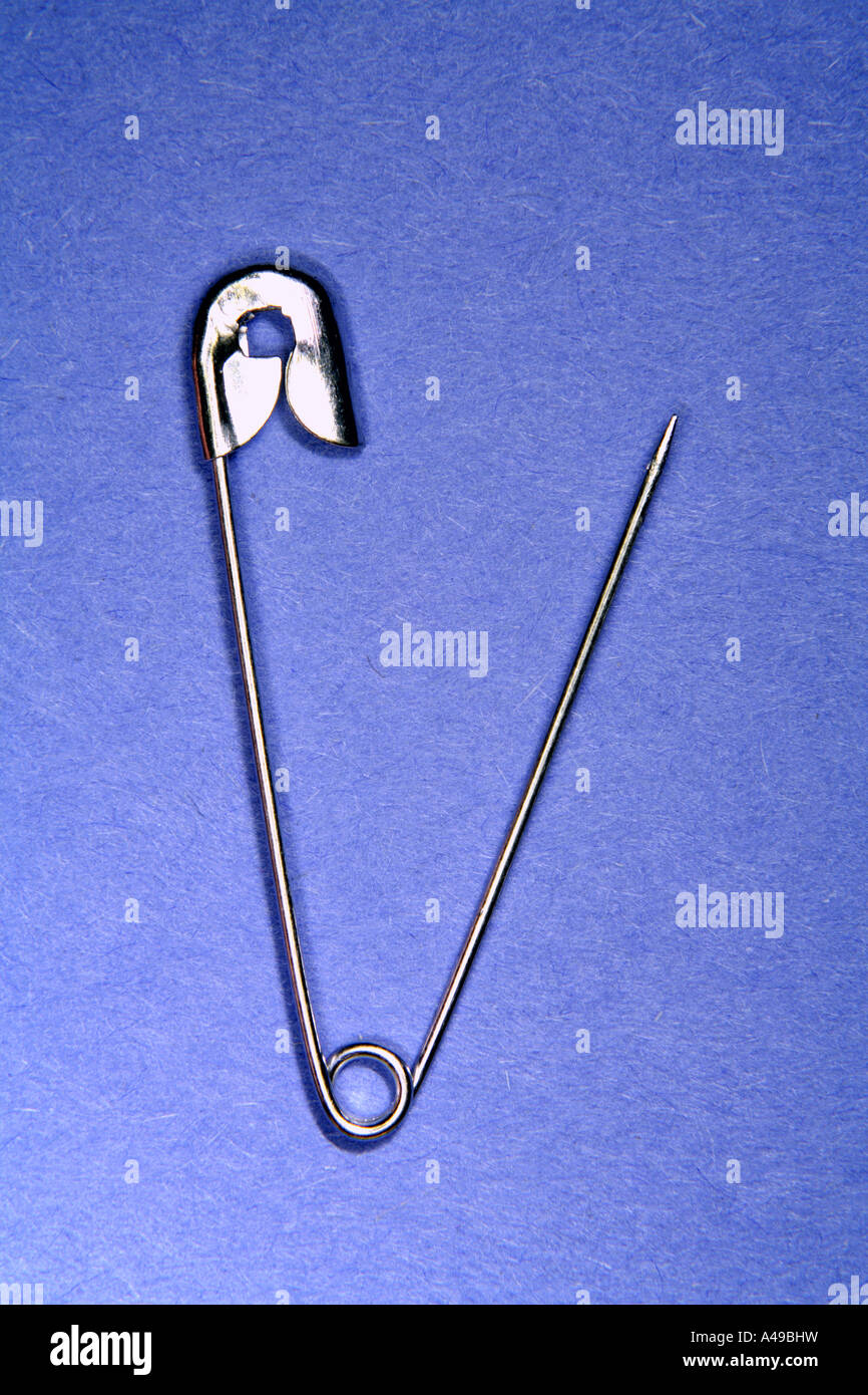 Safety pin on blue background Stock Photo - Alamy